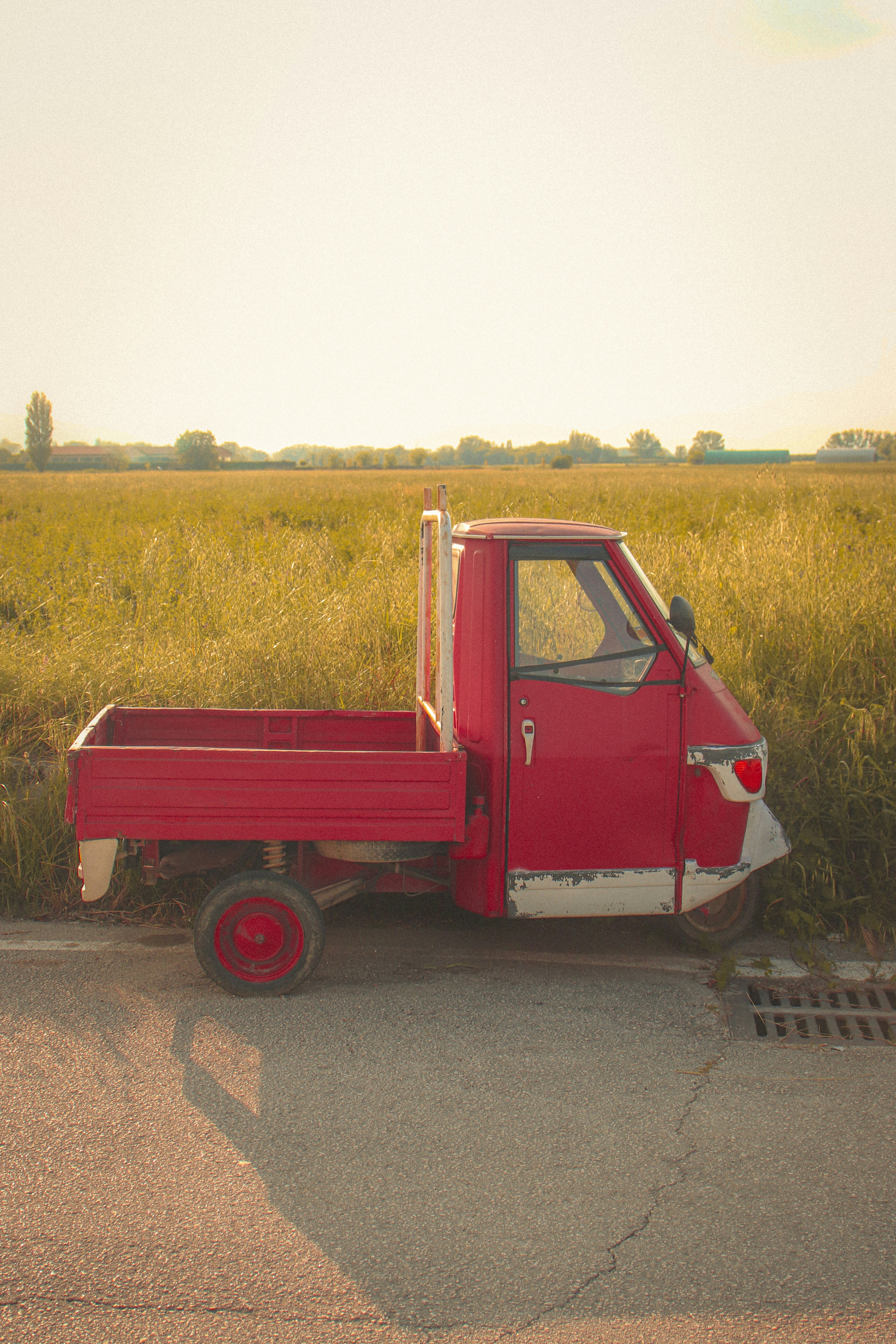 Sunlit Red Utility Trike on a Quiet Harvest Road