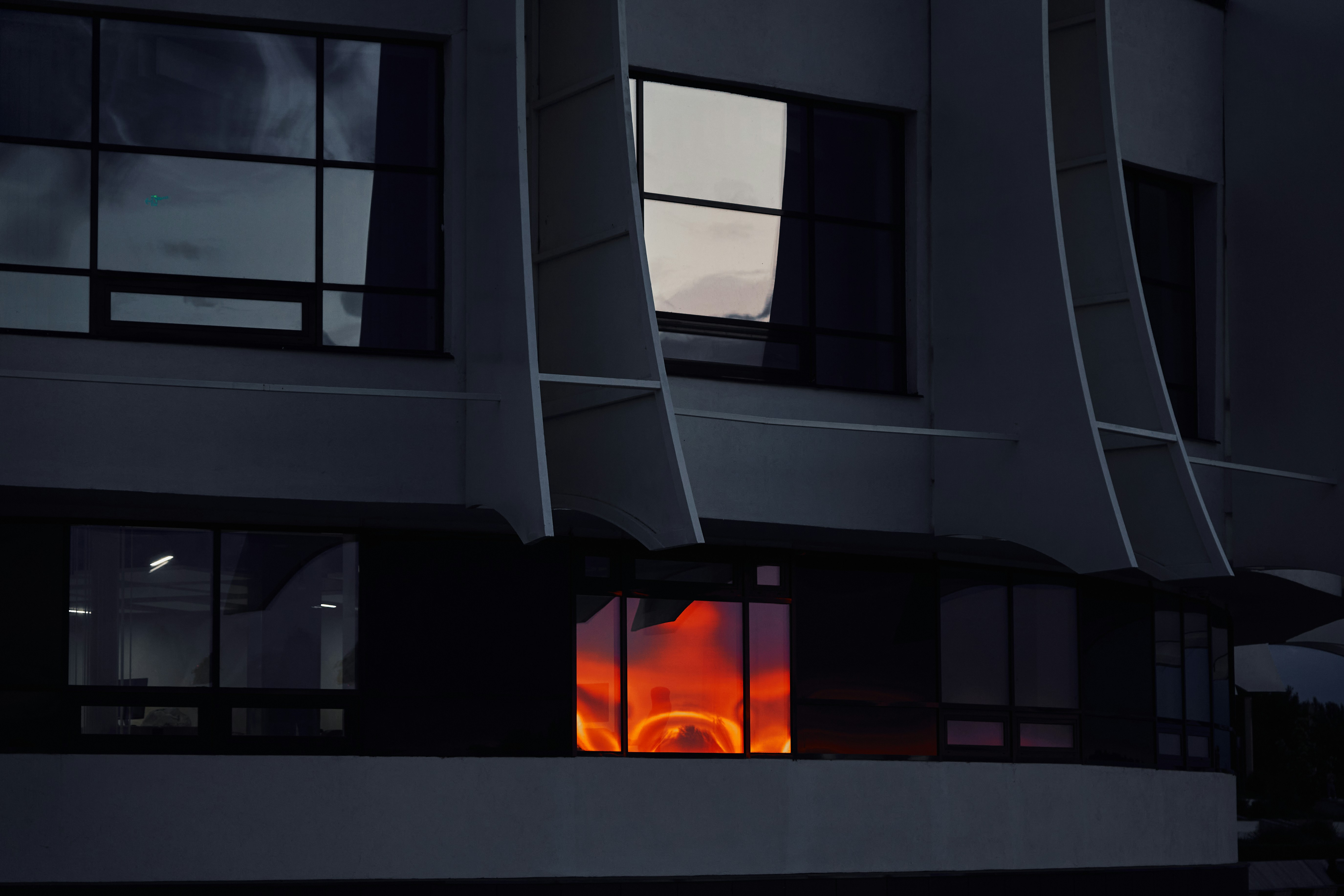 Crimson Window in a Monochrome Modern Facade