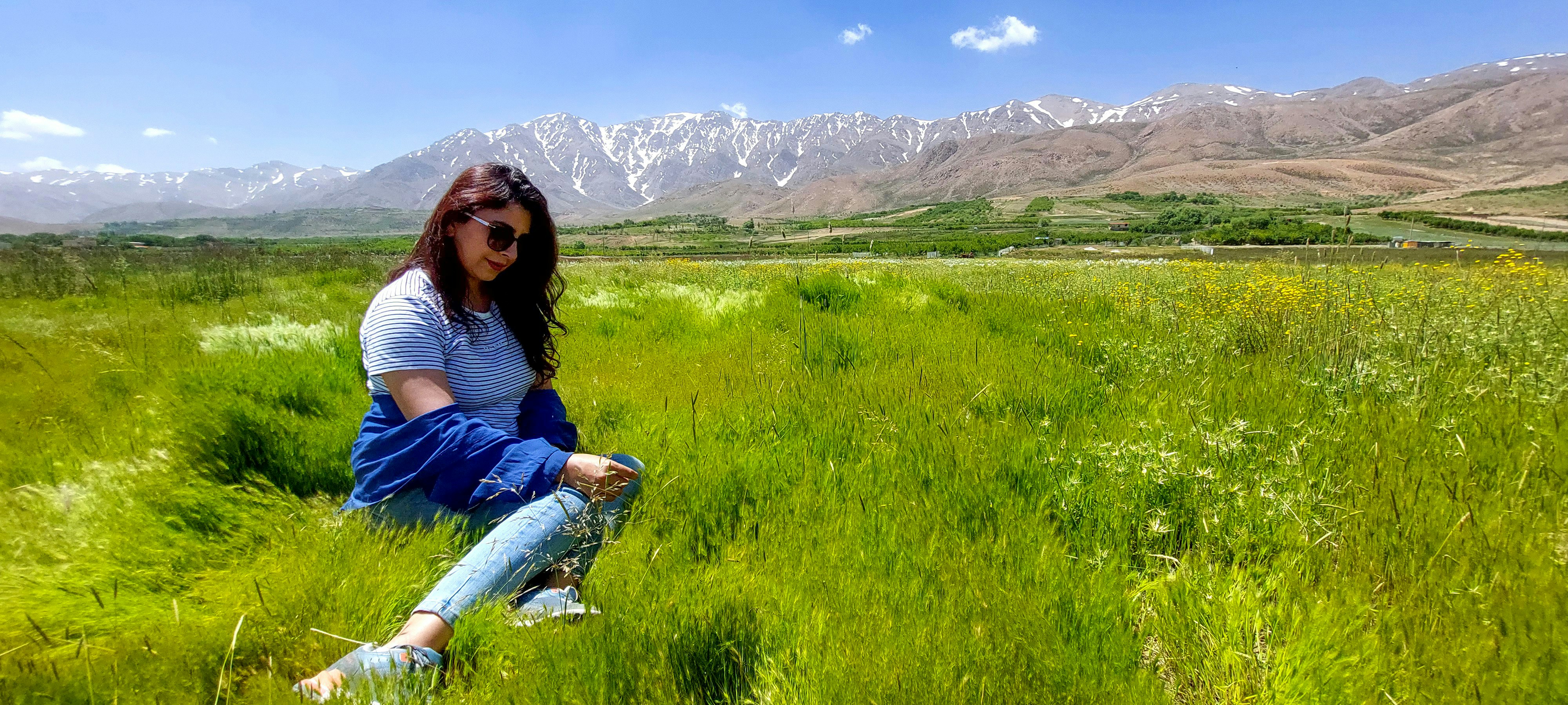Emerald Field Portrait Beneath Snowy Peaks