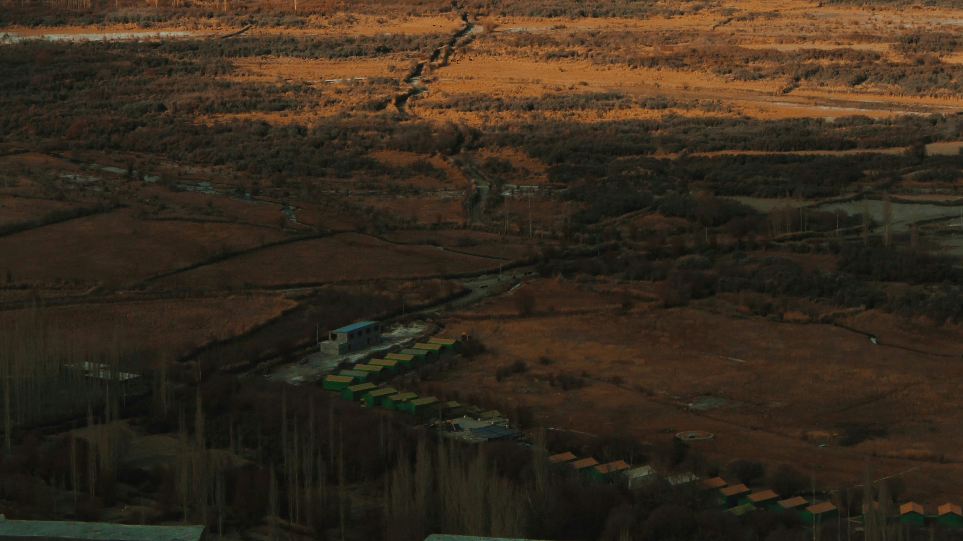 An aerial view of a field with trees and buildings photo – Free ...