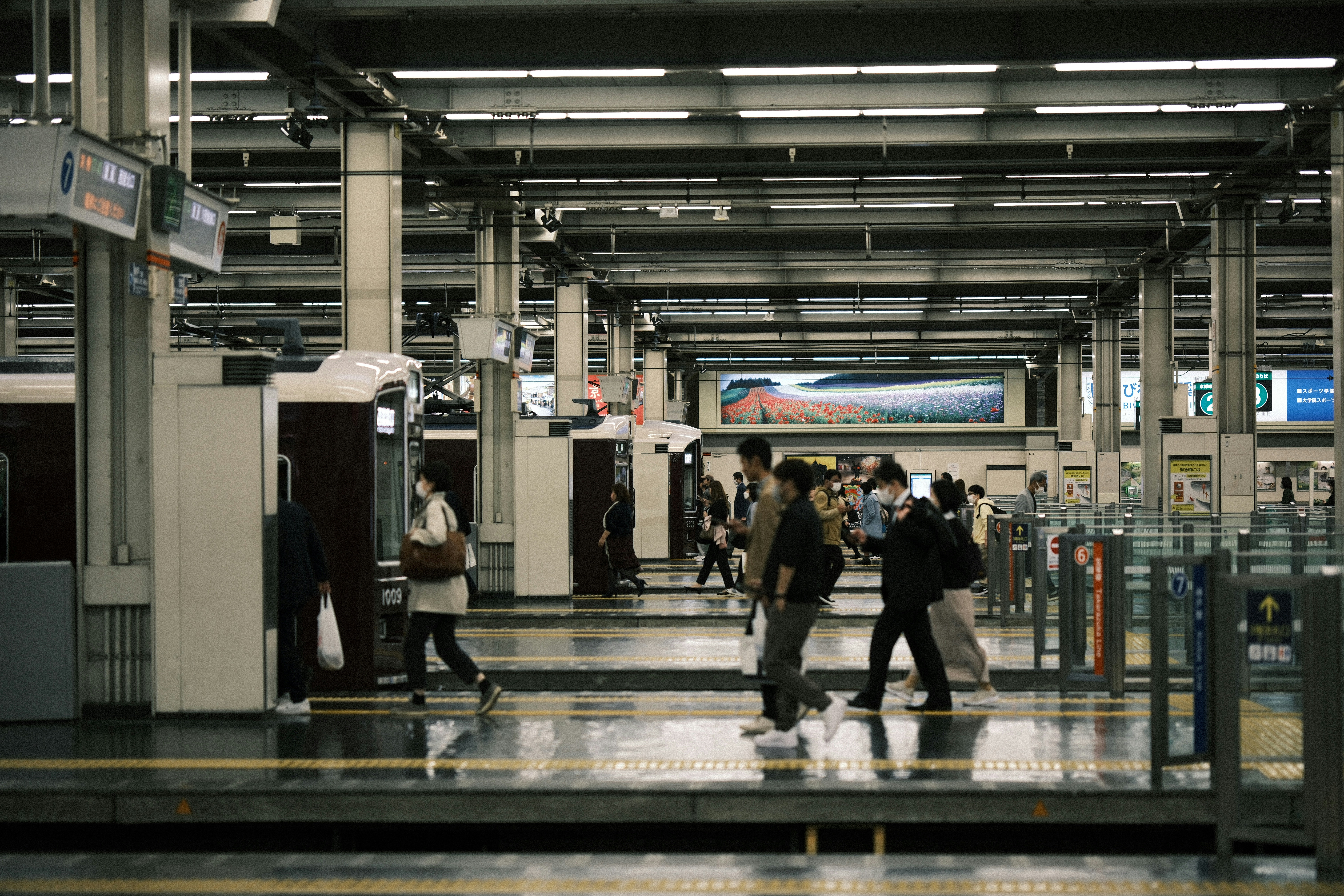 A group of people walking through a train station photo – Free Train ...