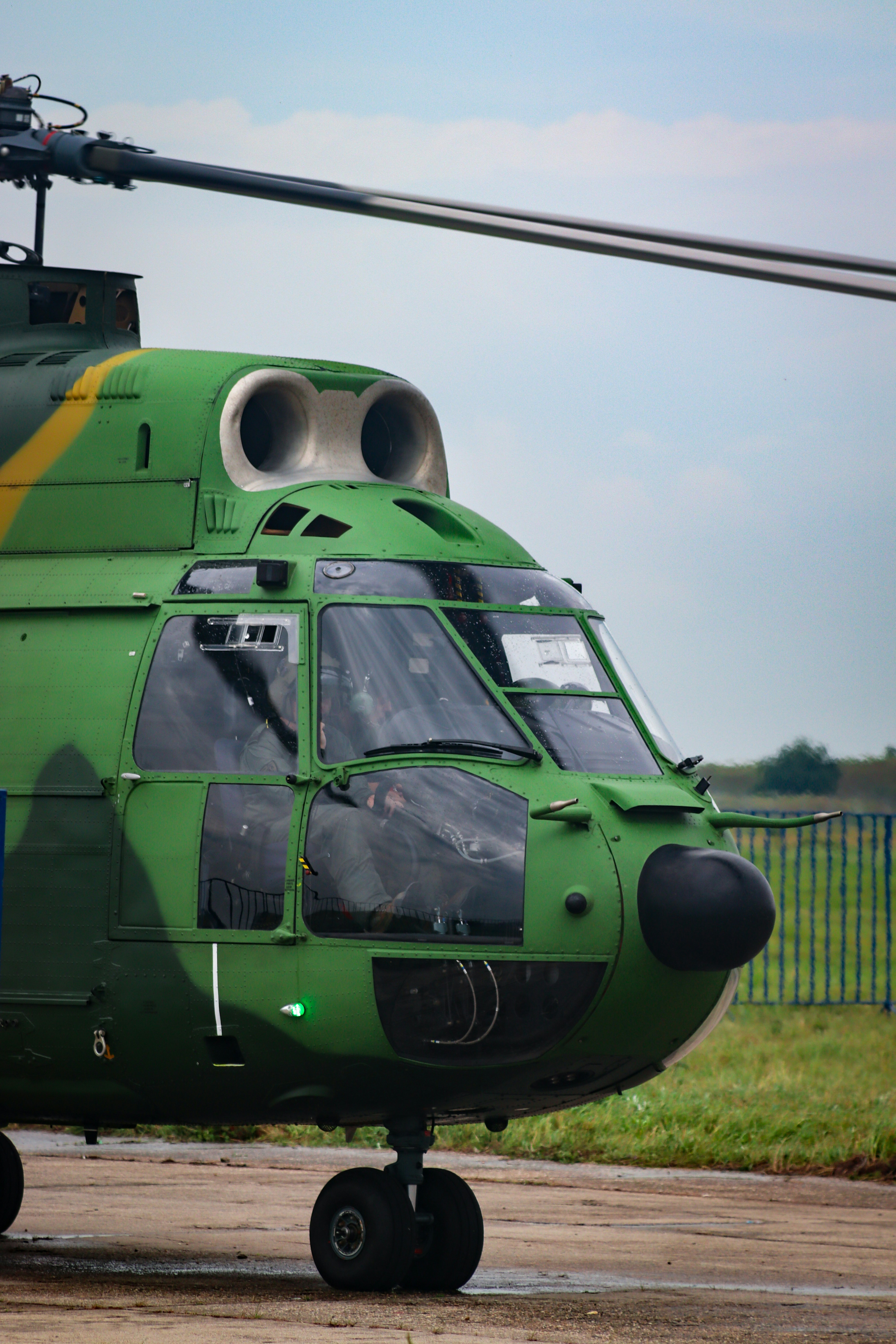 A green helicopter sitting on top of an airport tarmac photo – Free ...