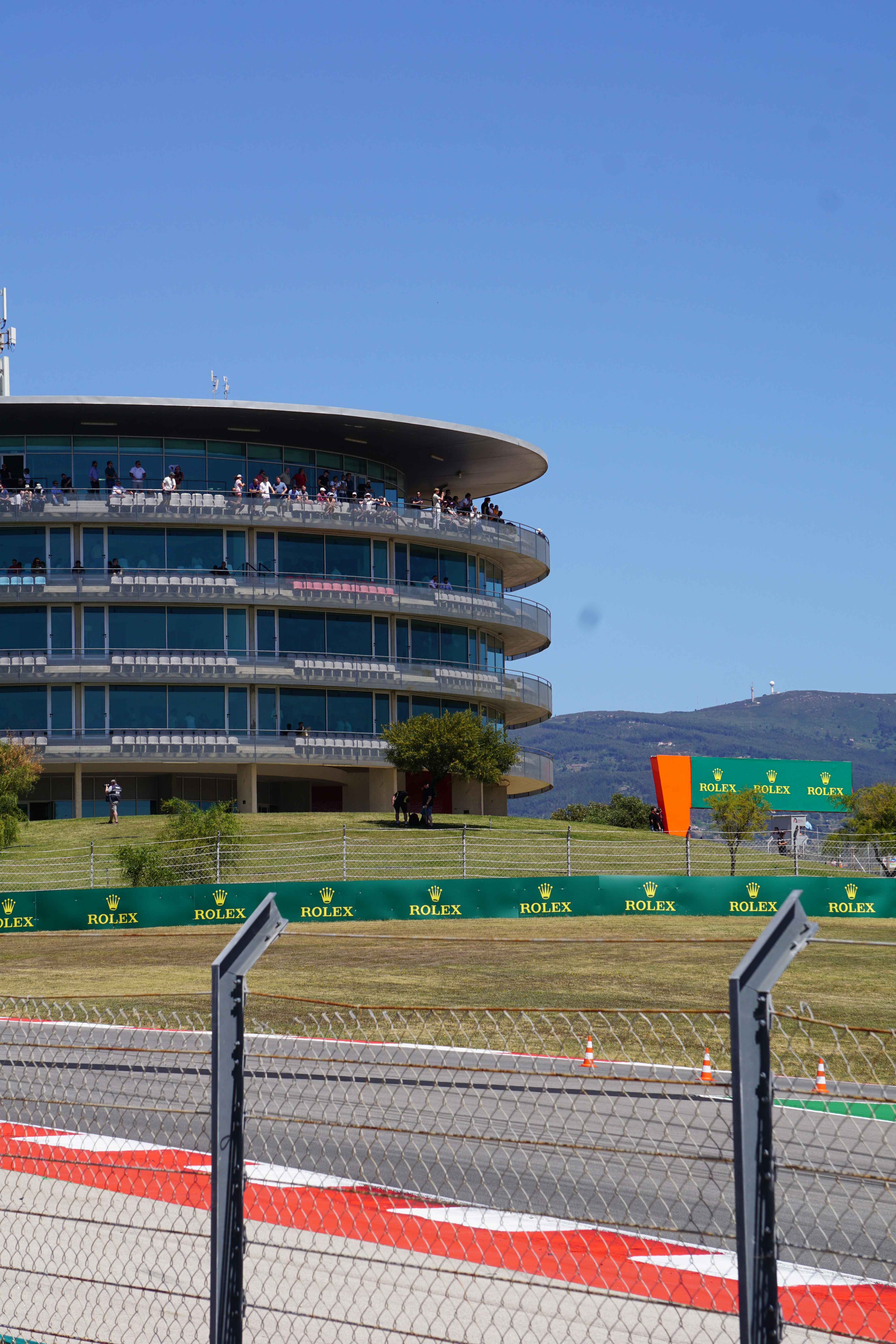 A race track with a large building in the background photo – Free ...