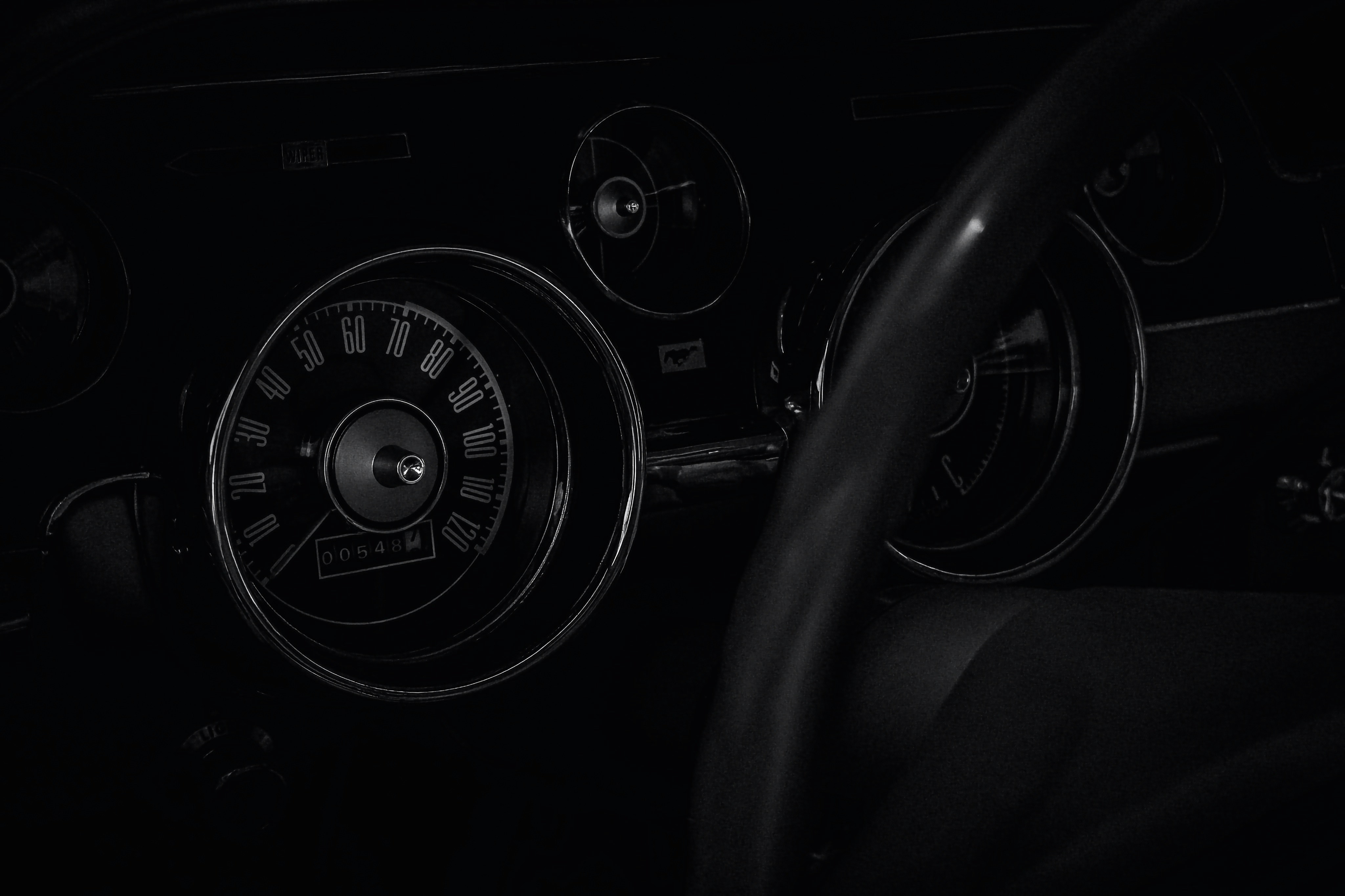 Chrome Circles in Darkness: A Vintage Car Dashboard at Night