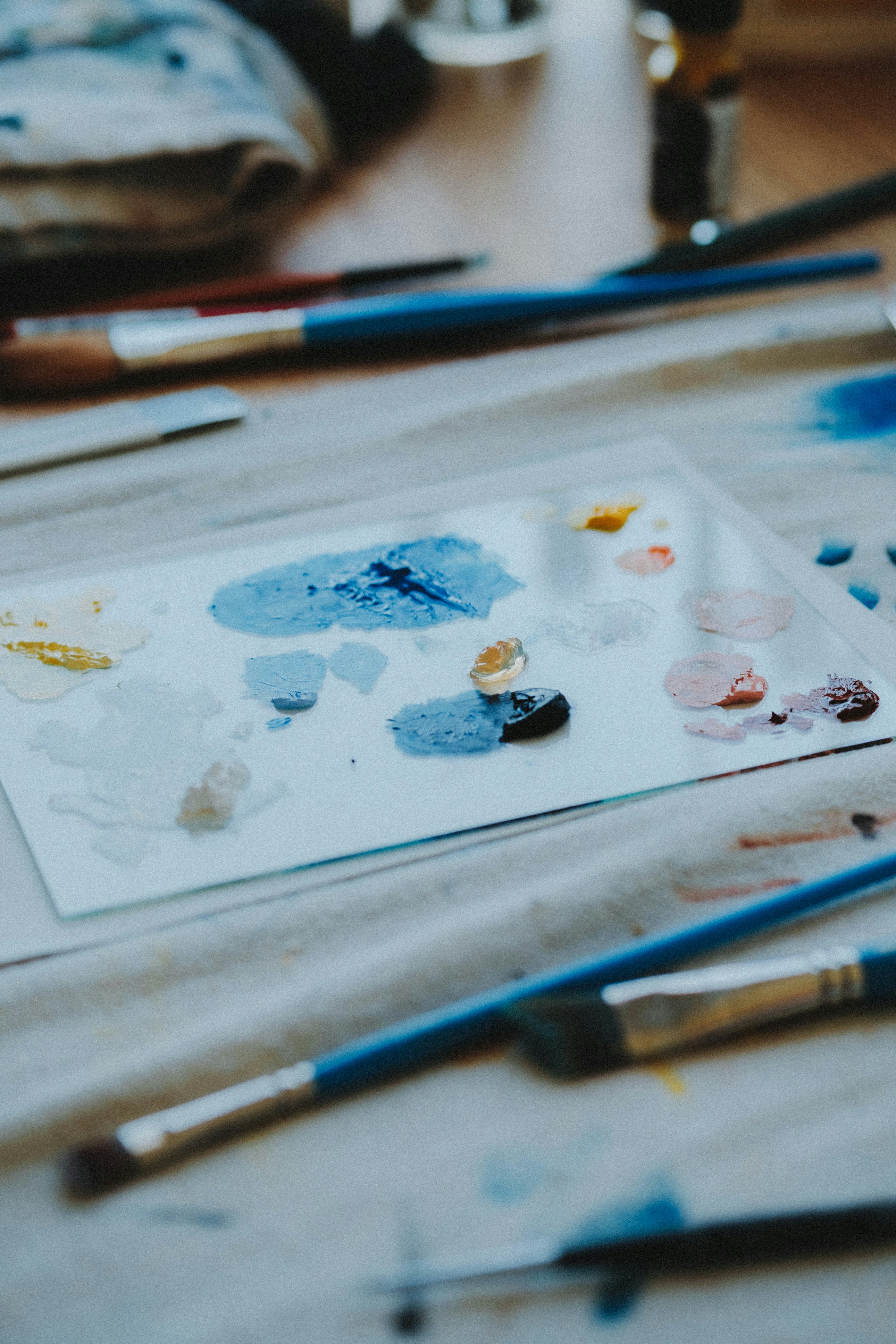 A table topped with lots of paint and brushes photo – Free Paint Image ...