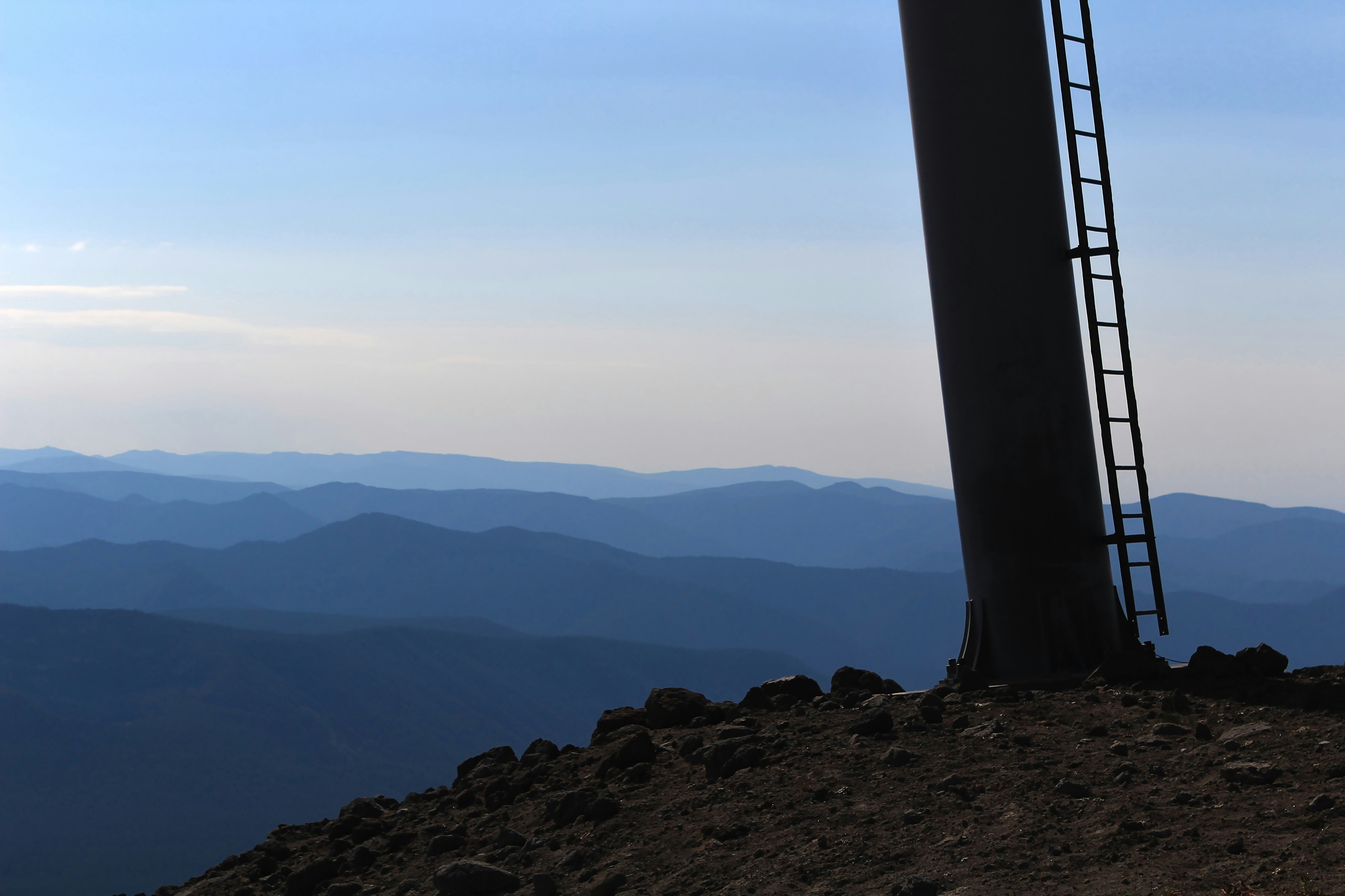 Laddered Ridge: Vertical Silhouette Against Layered Blue Valleys