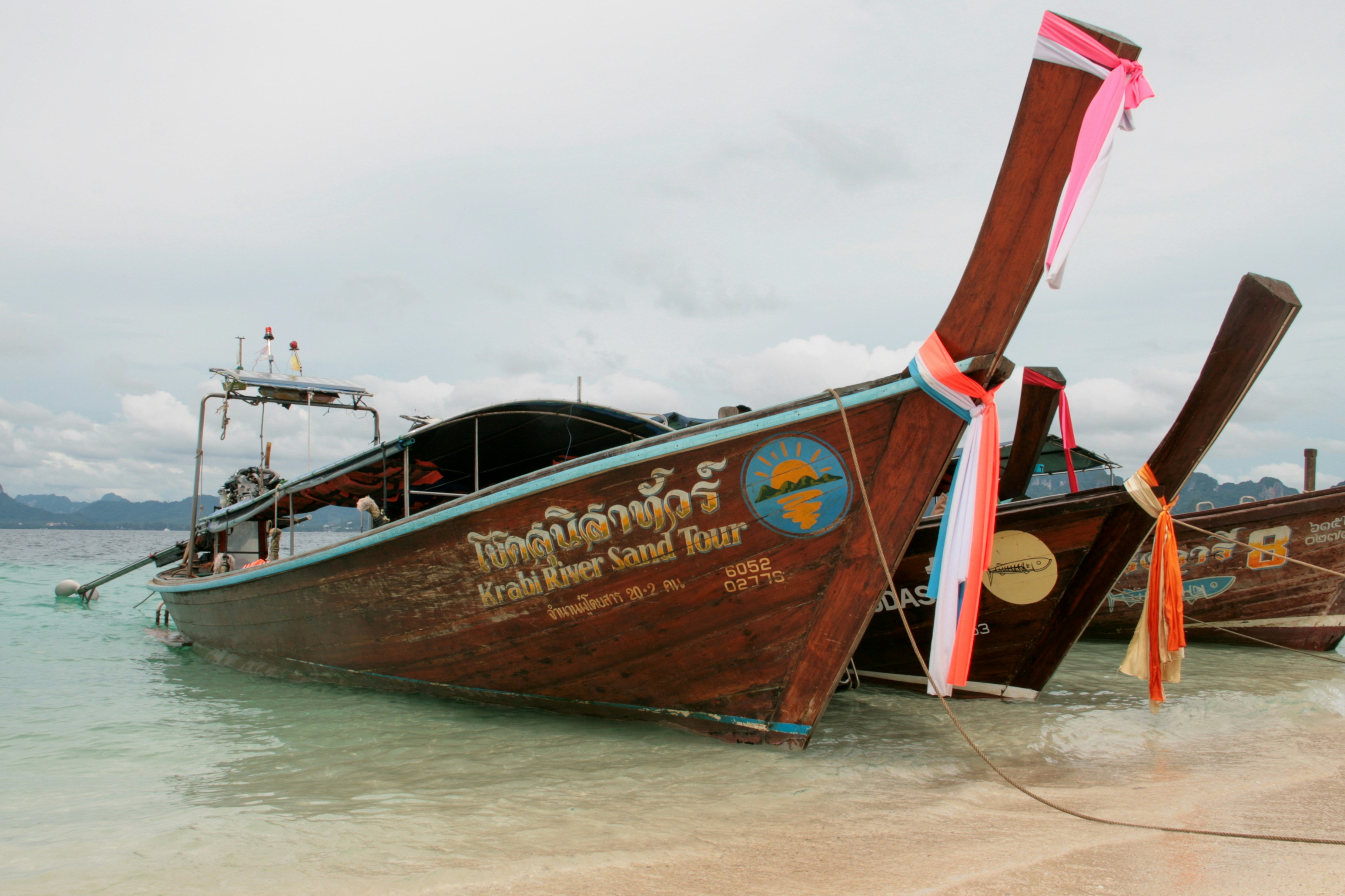 Color-Wrapped Long-Tail Boats Moored at a Turquoise Thai Shore