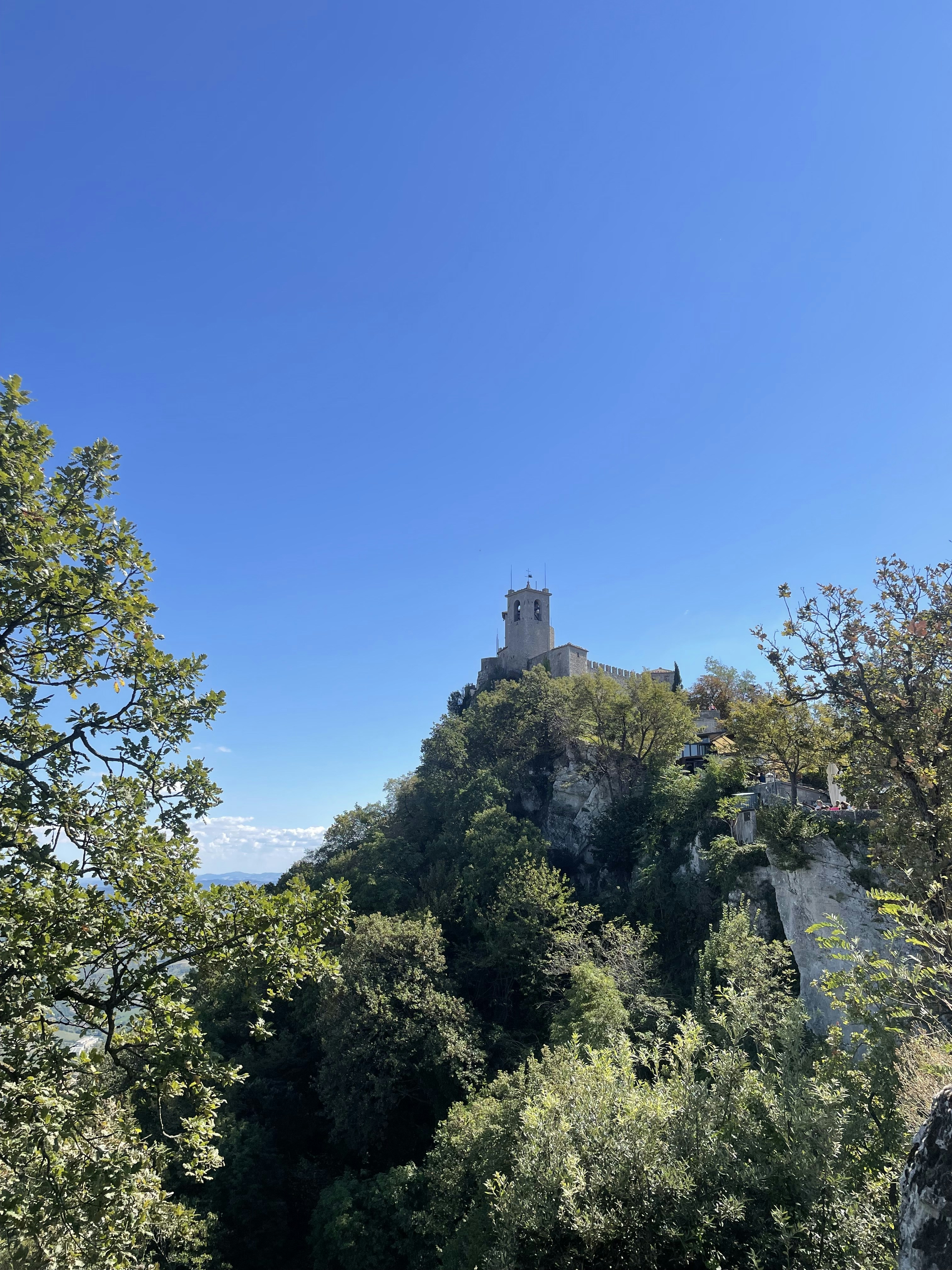 Un château au sommet d’une colline entourée d’arbres photo – Photo ...