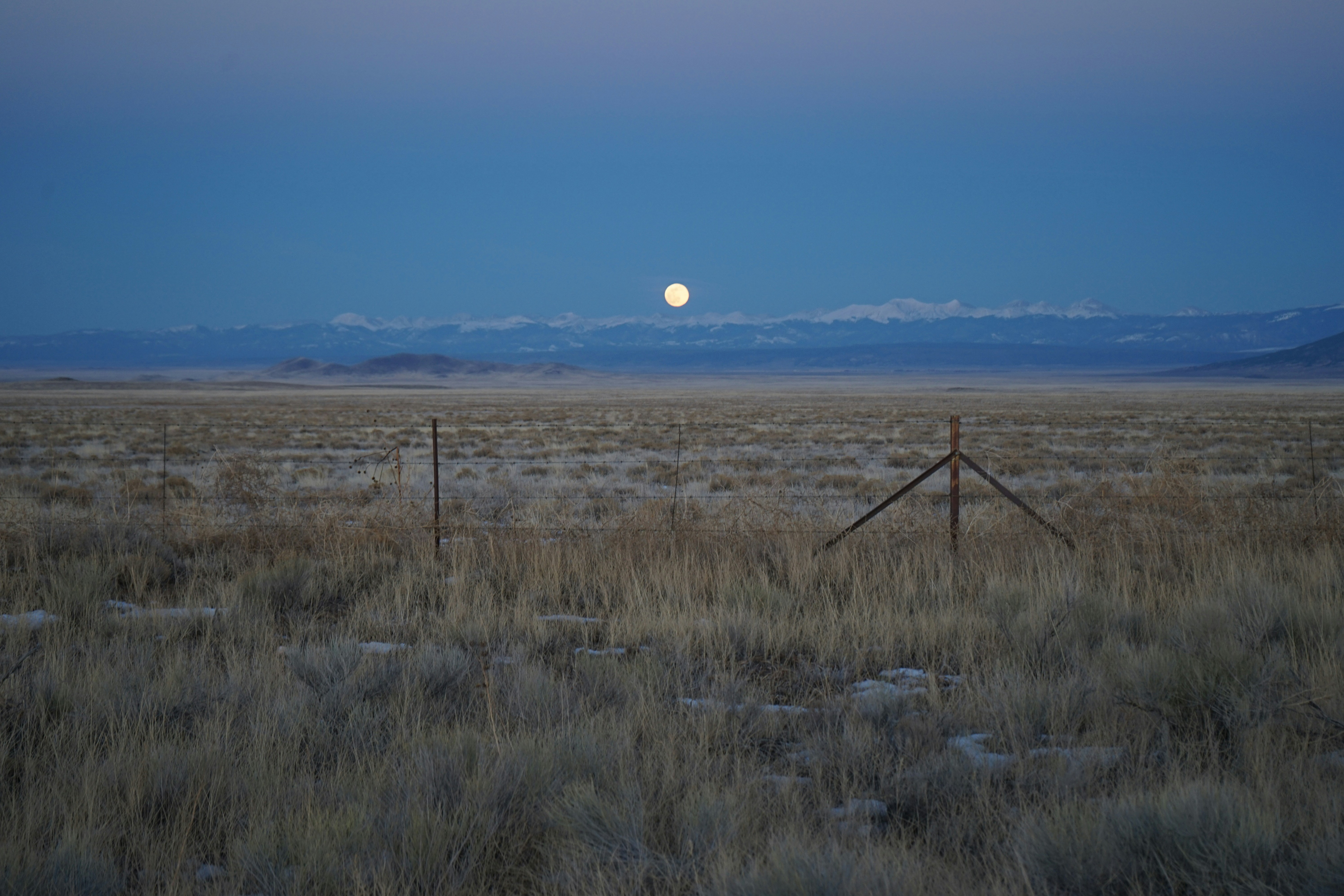 Moonrise over a quiet prairie fence