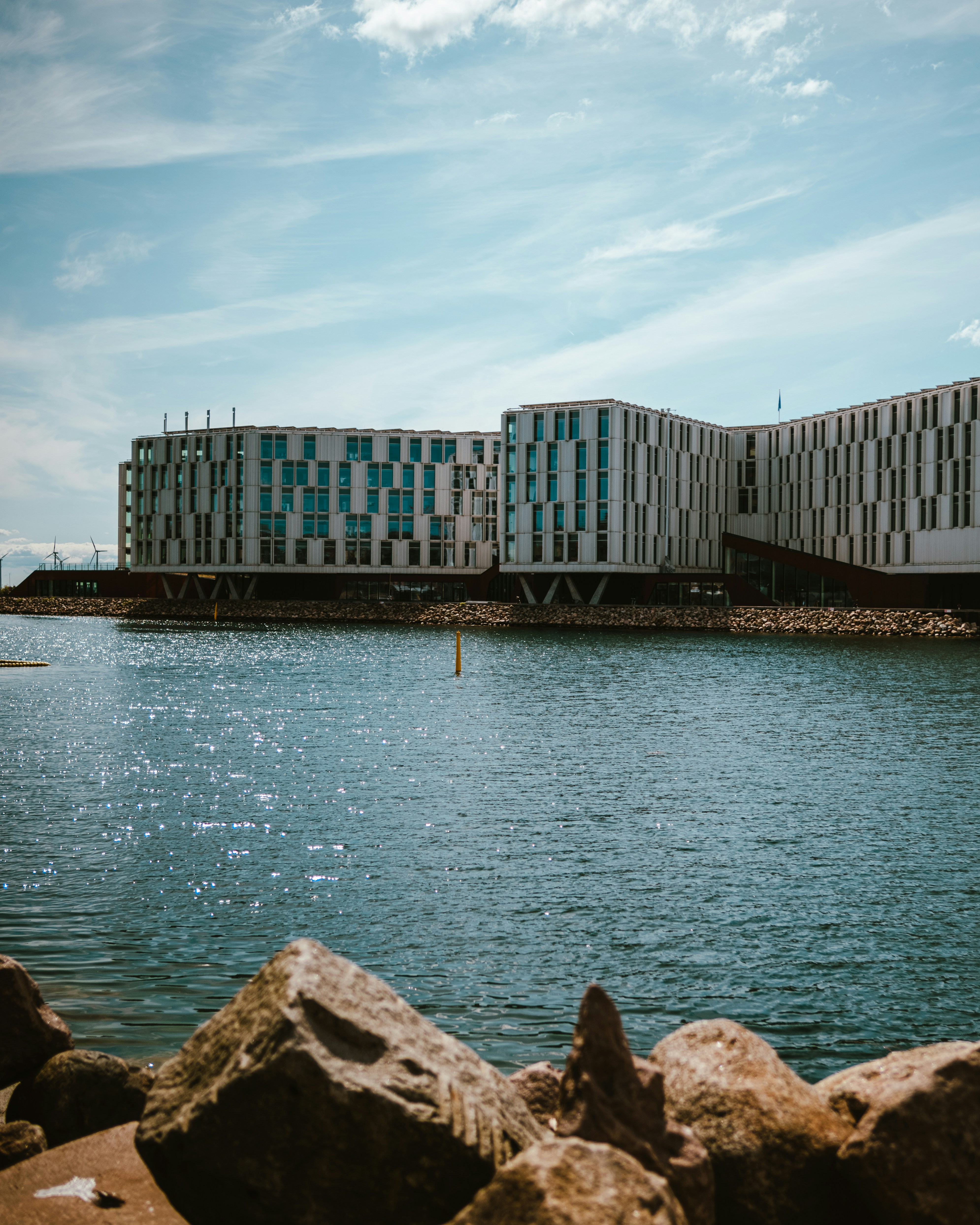Harborfront Geometry: Glass Facades Rise Over Tranquil Waters