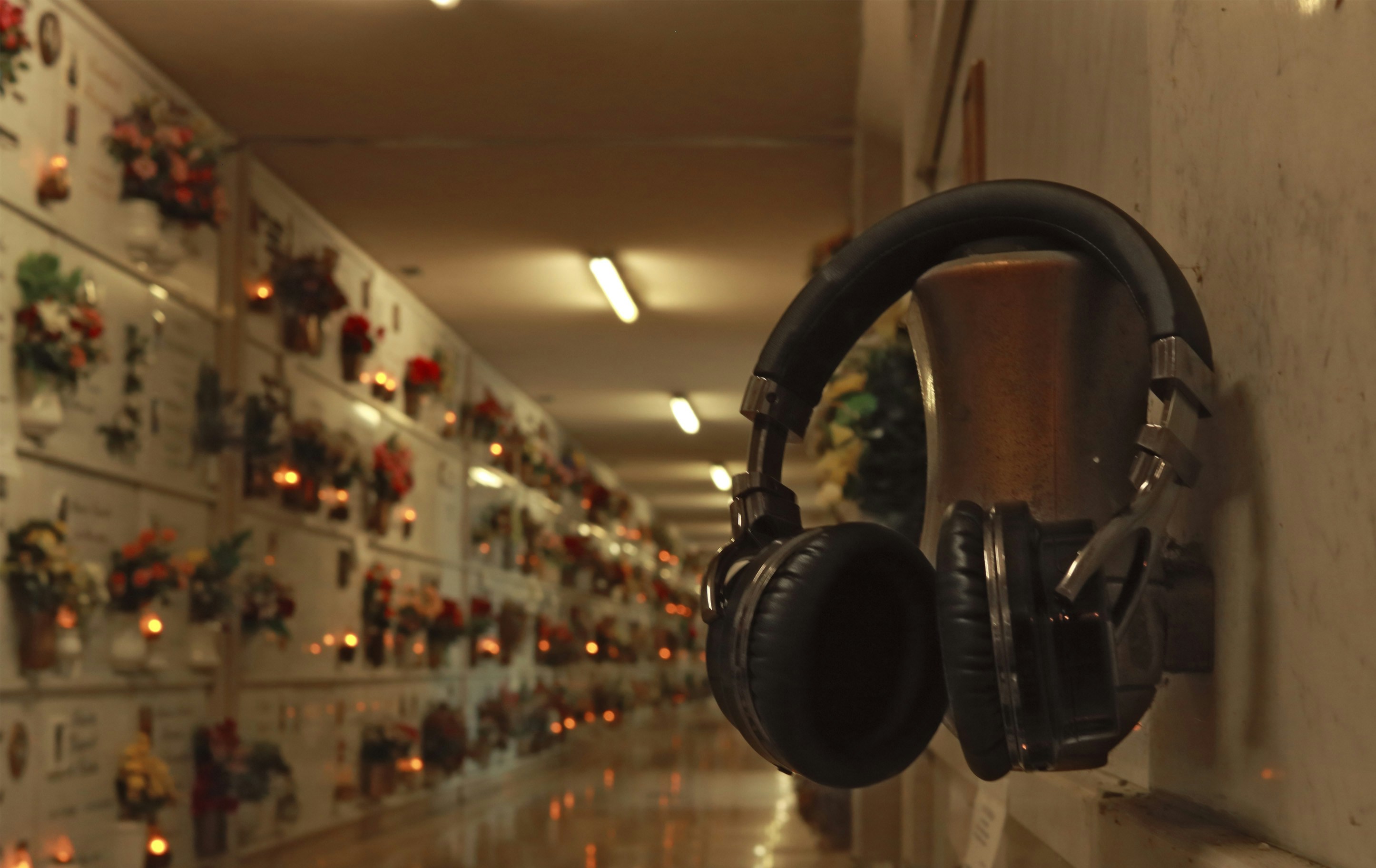 Echoes on the Wall: Headphones in a Candlelit Memorial Corridor