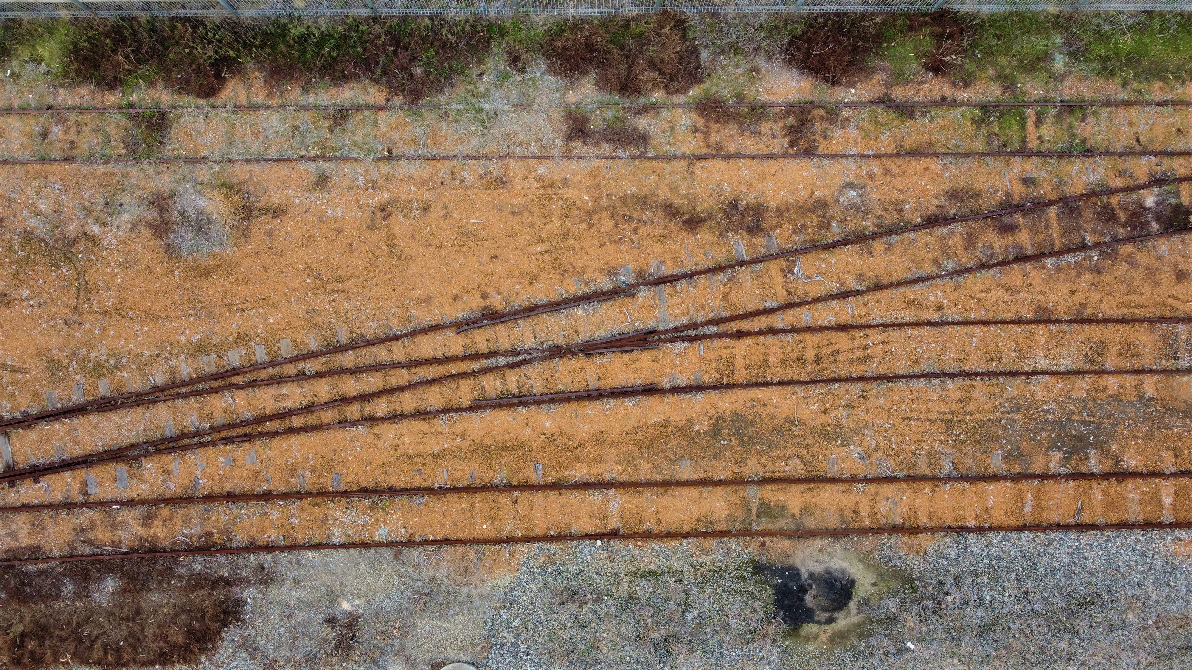 Rust-Orange Ground with Parallel Tracks: An Aerial Study
