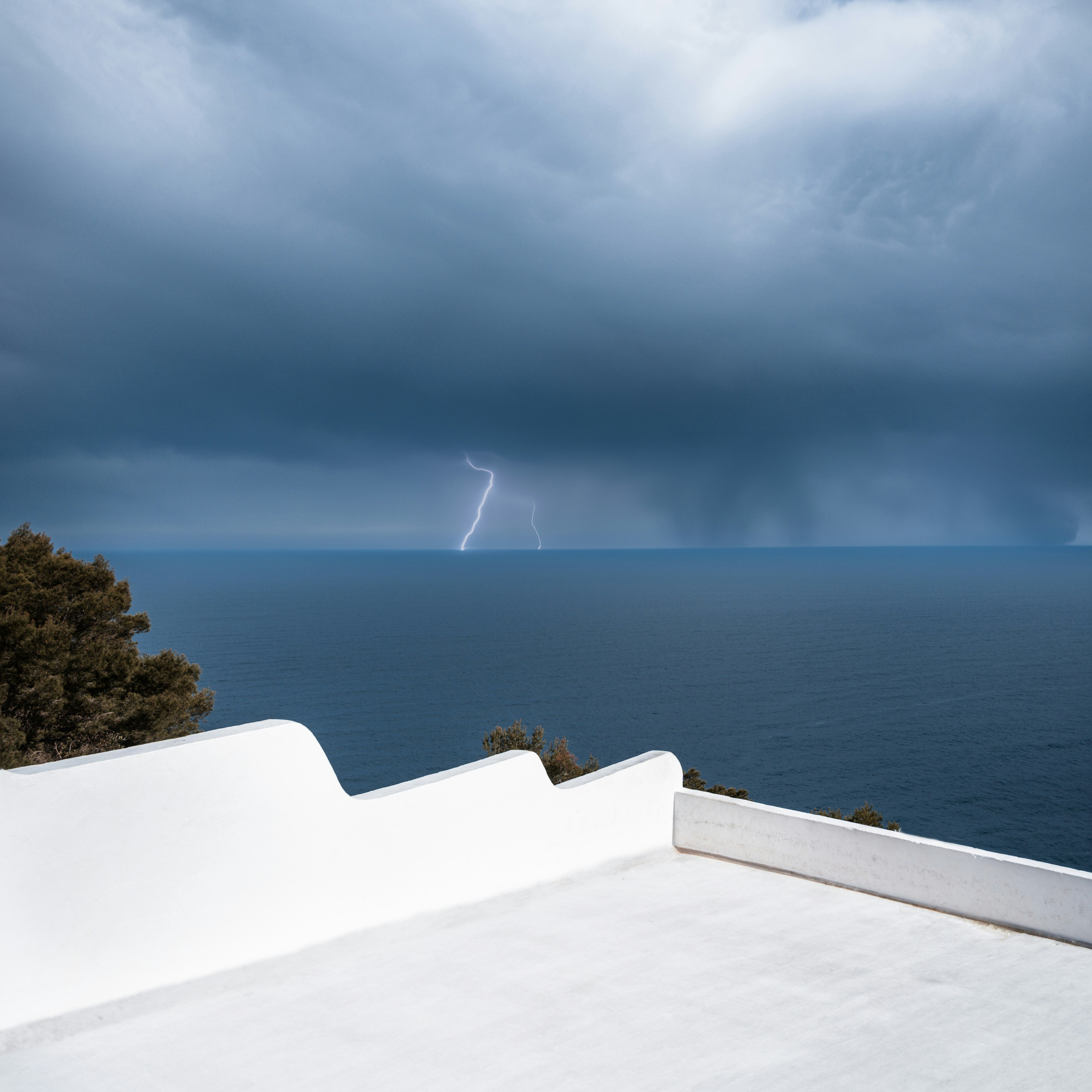A lightning bolt is seen in the distance over the ocean photo – Free ...
