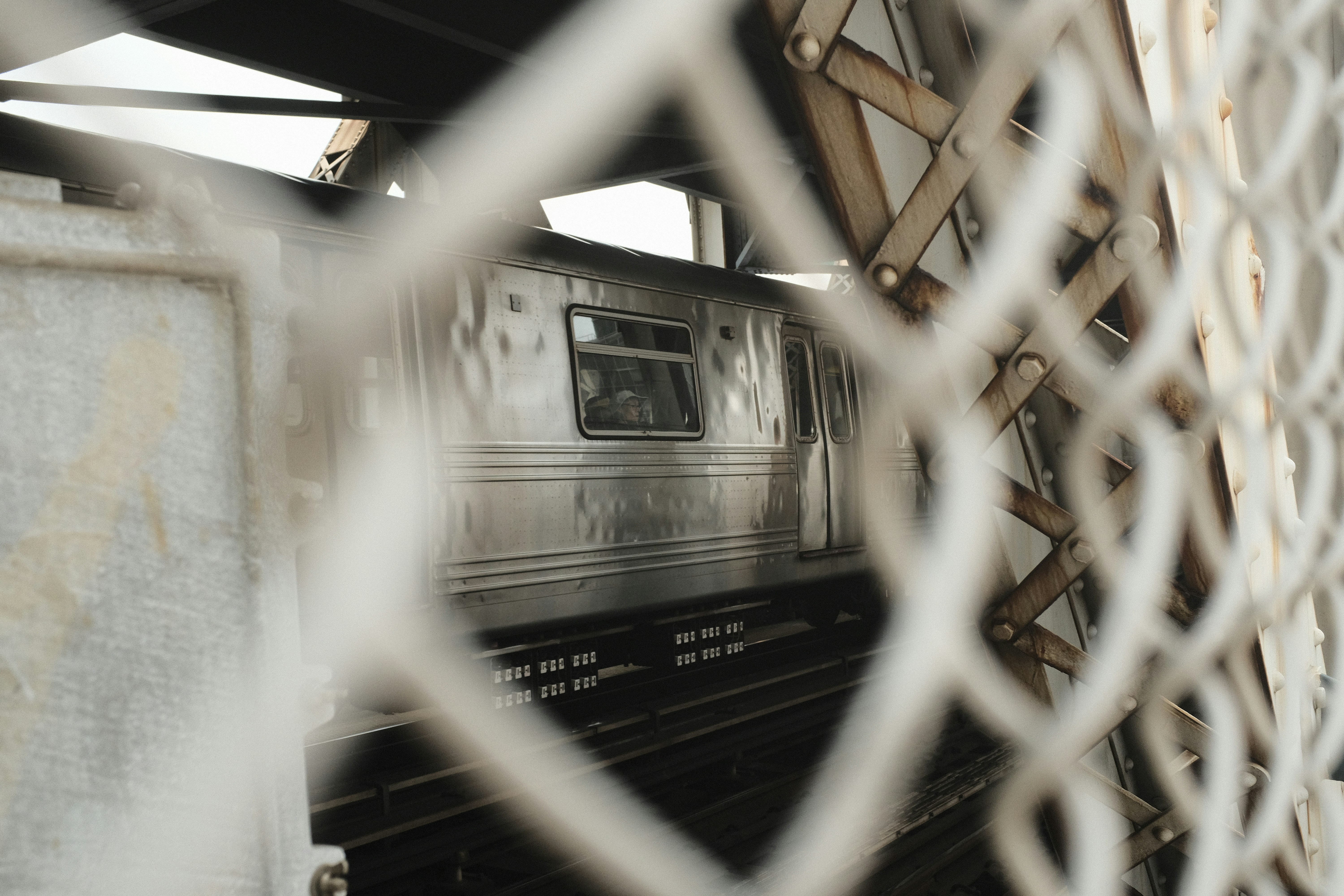 Chain-Link Frame: Subway Car Framed by Industrial Mesh