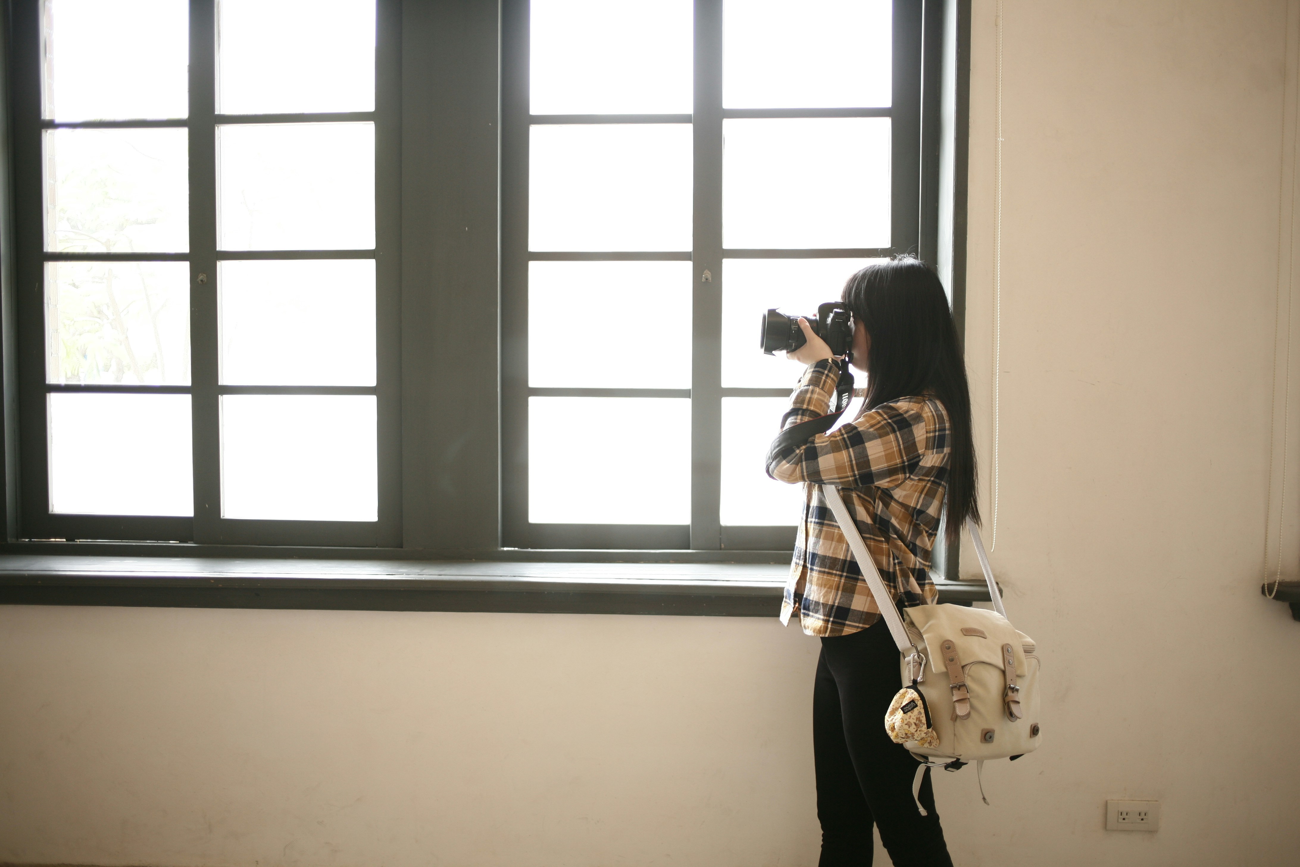 Window-Side Focus: A Plaid-Clad Photographer in Quiet Light