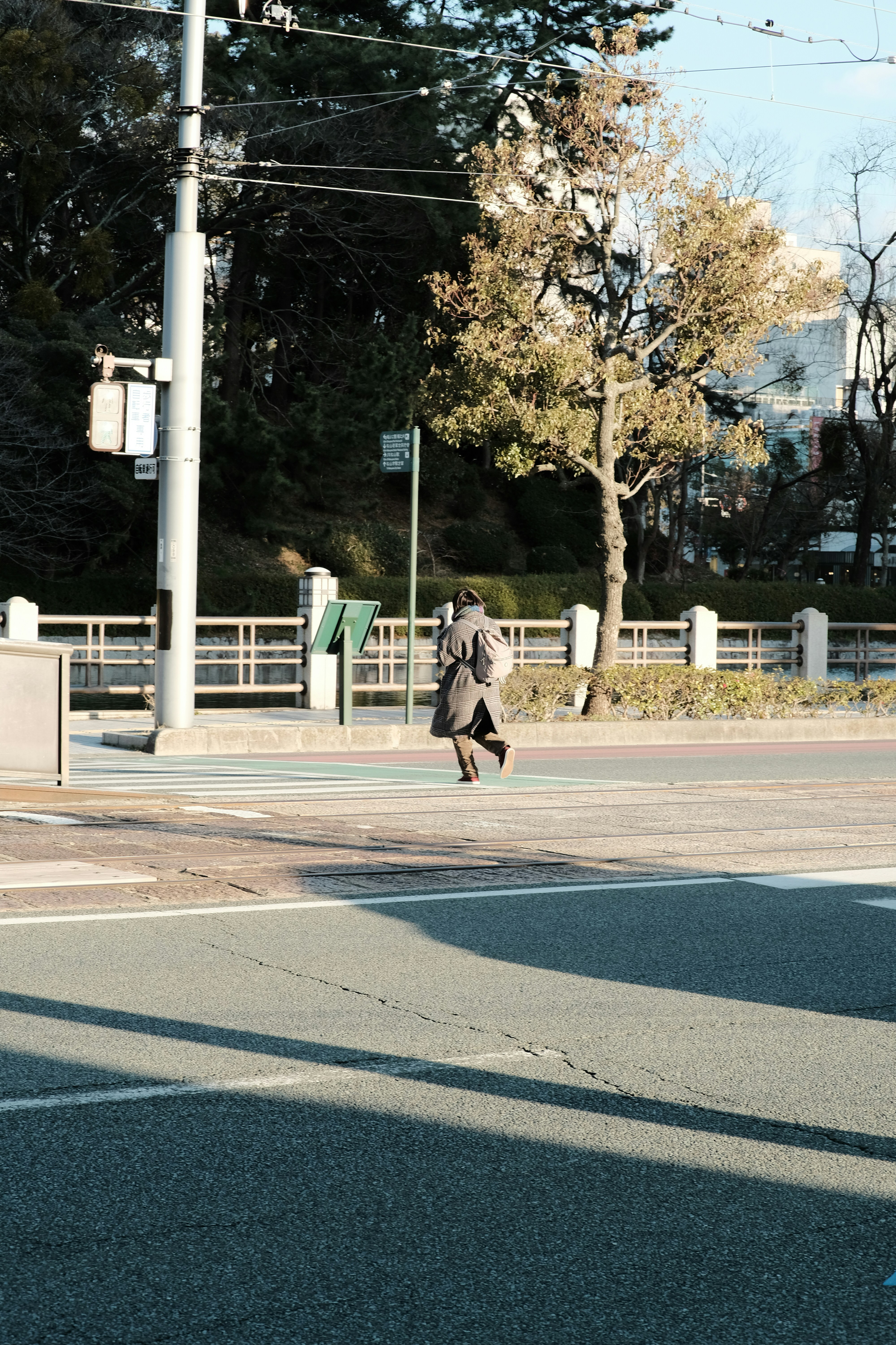 A man running across a street next to a traffic light photo – Free City ...