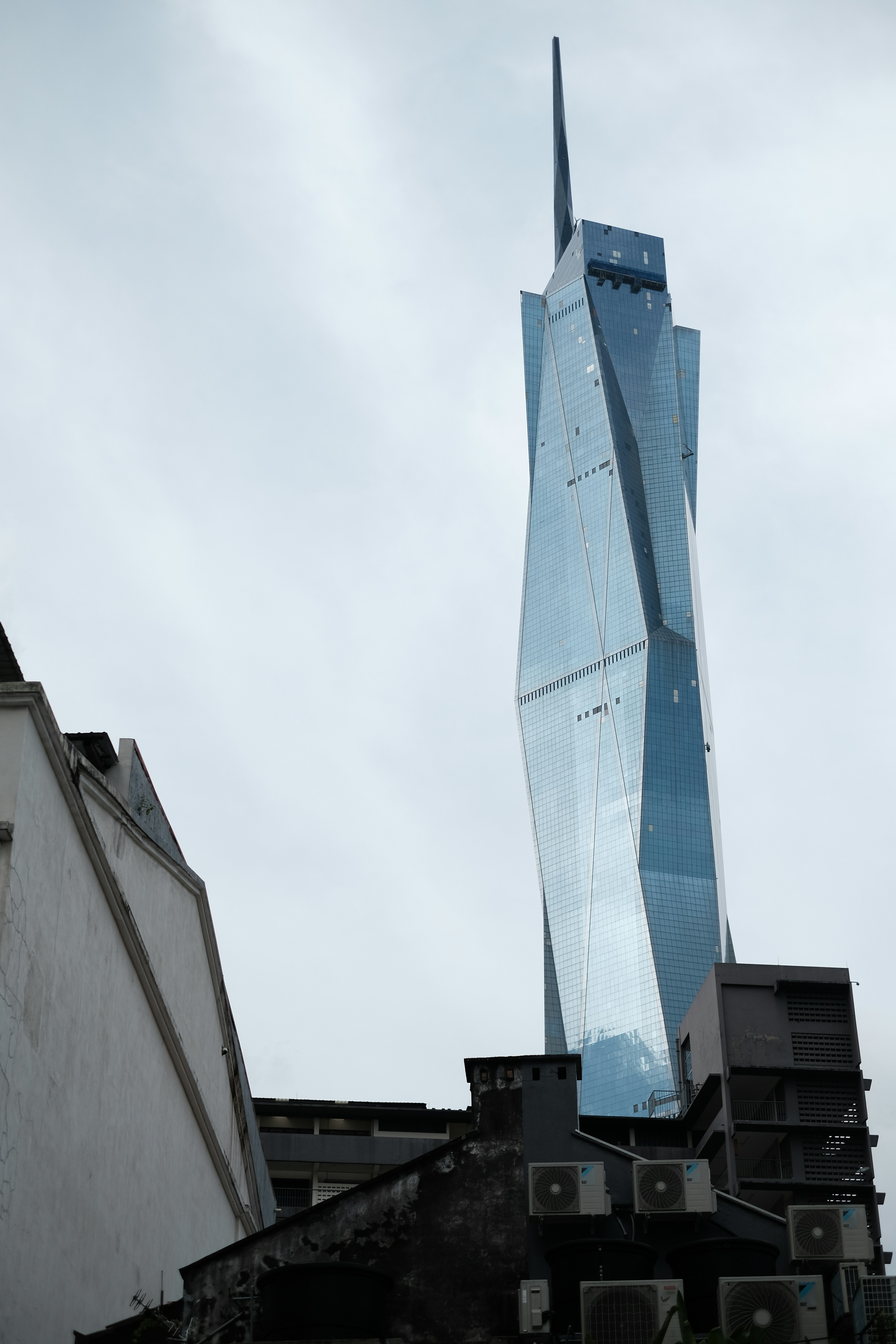 Azure Facet Spire Rising Over Rooftop Machinery