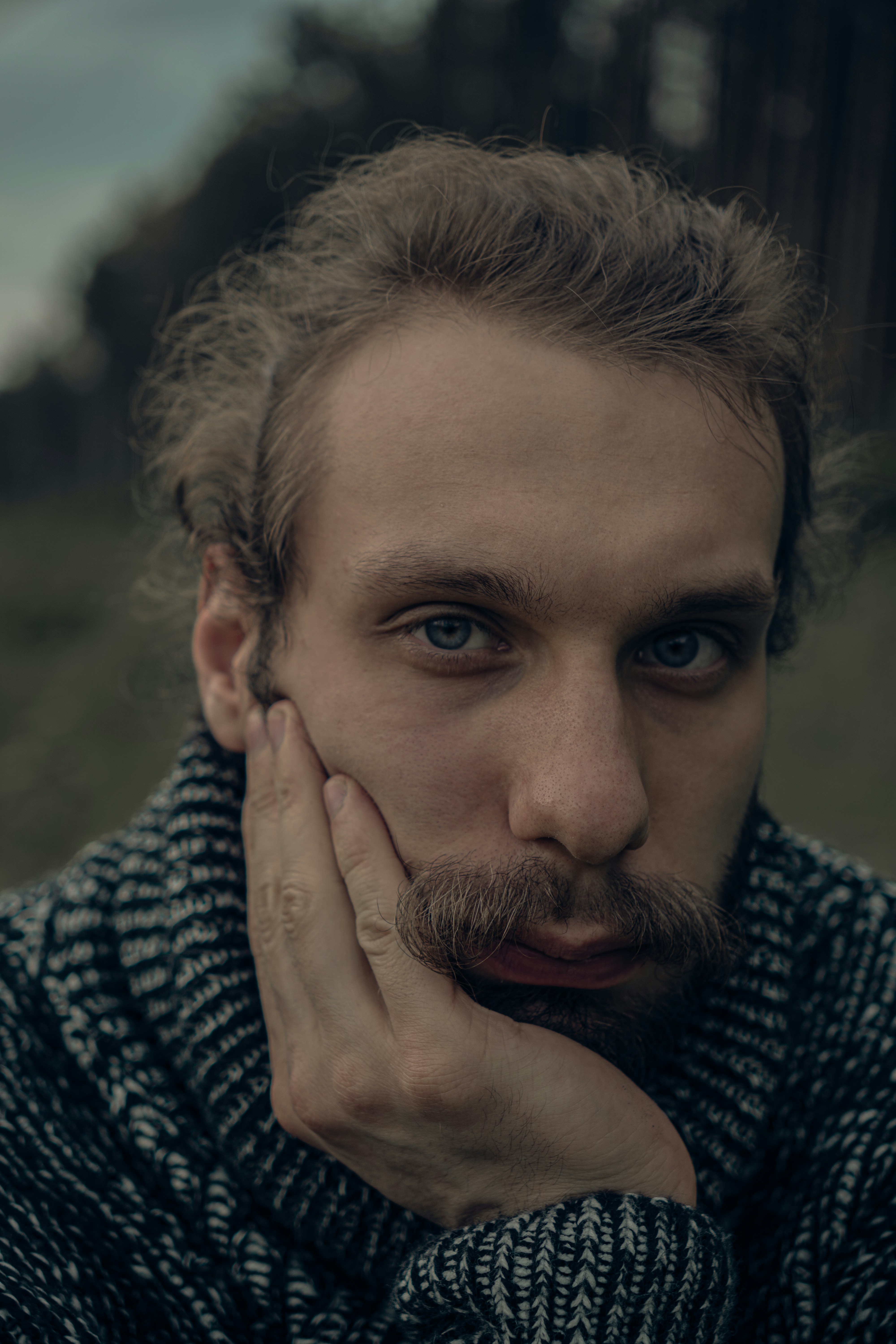 Un homme aux cheveux longs et à la barbiche fixe la caméra photo ...