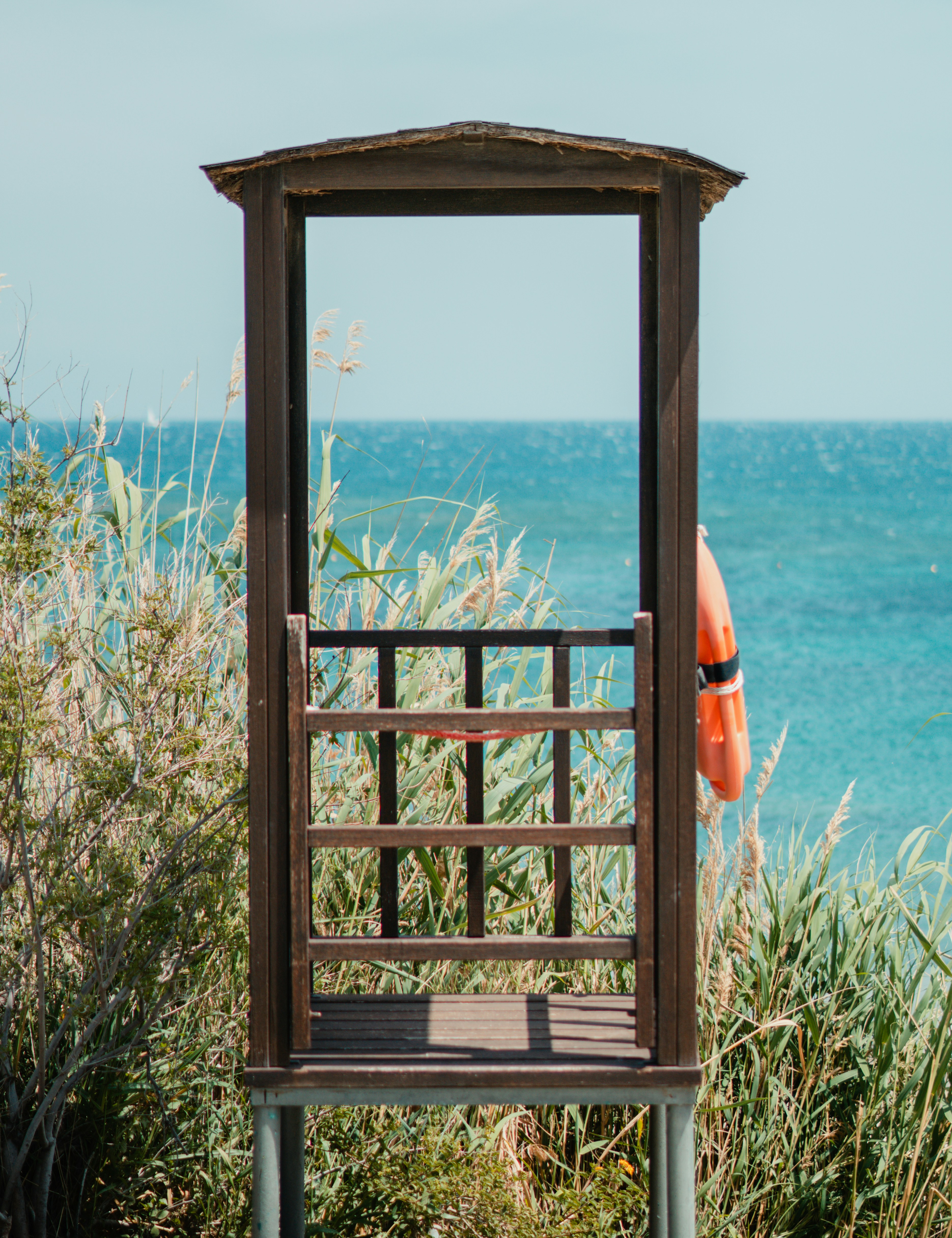 Wooden Portal to the Sea: A Lifeguard Booth Framed by Coastal Grasses