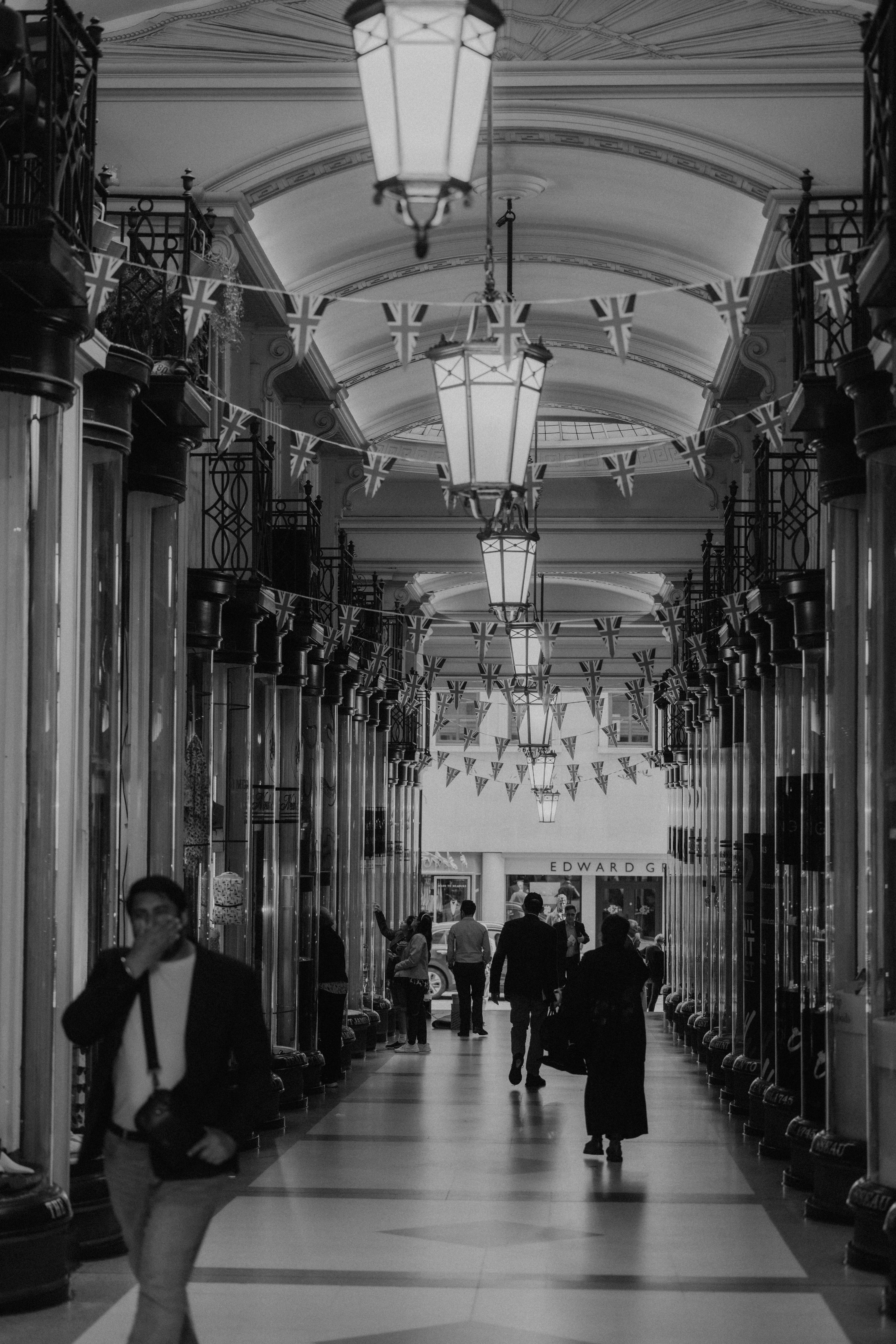 Vanishing Point Under Union Flags: Lantern-Lit Arcade Corridor