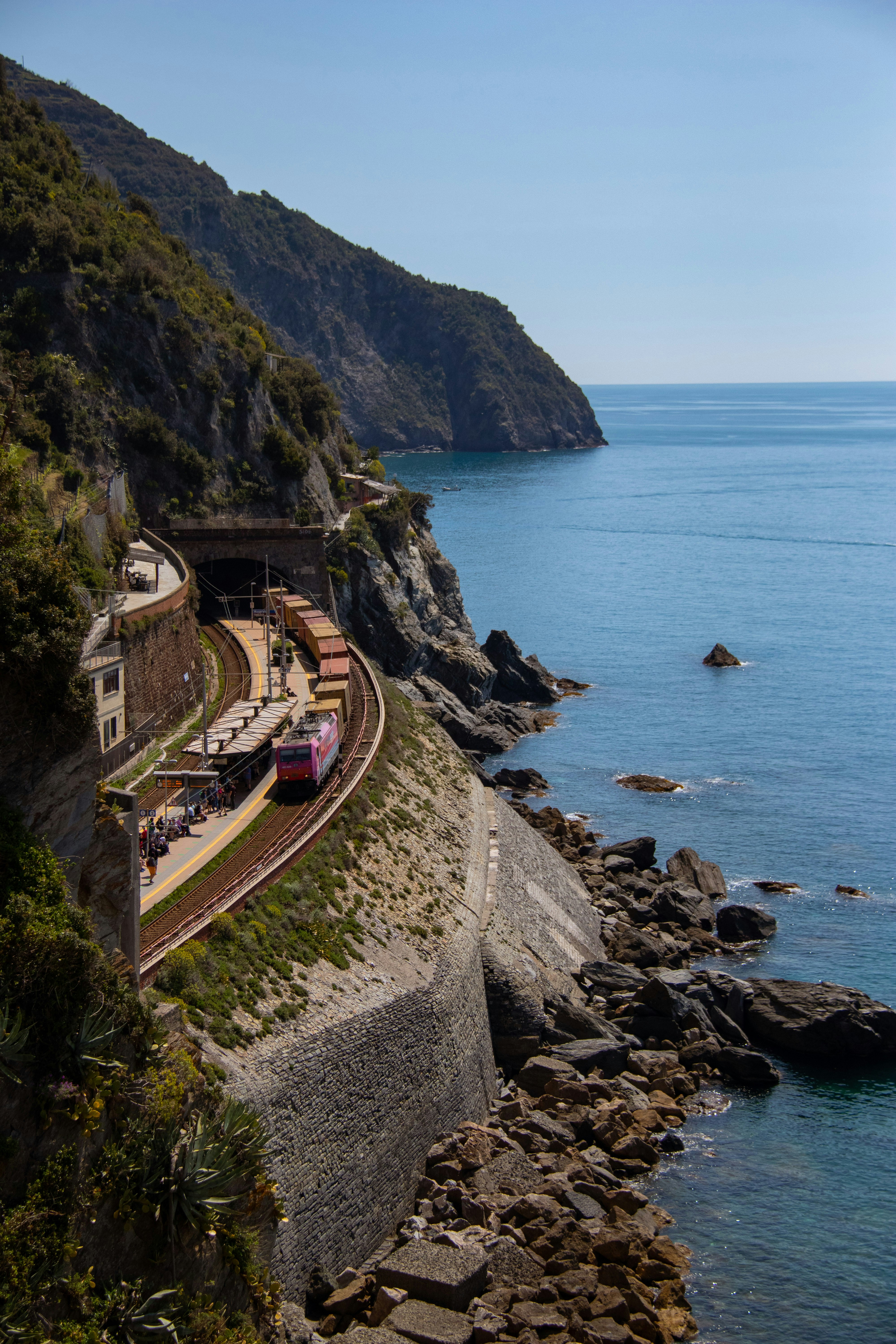 A train on a train track next to a body of water photo – Free Train ...
