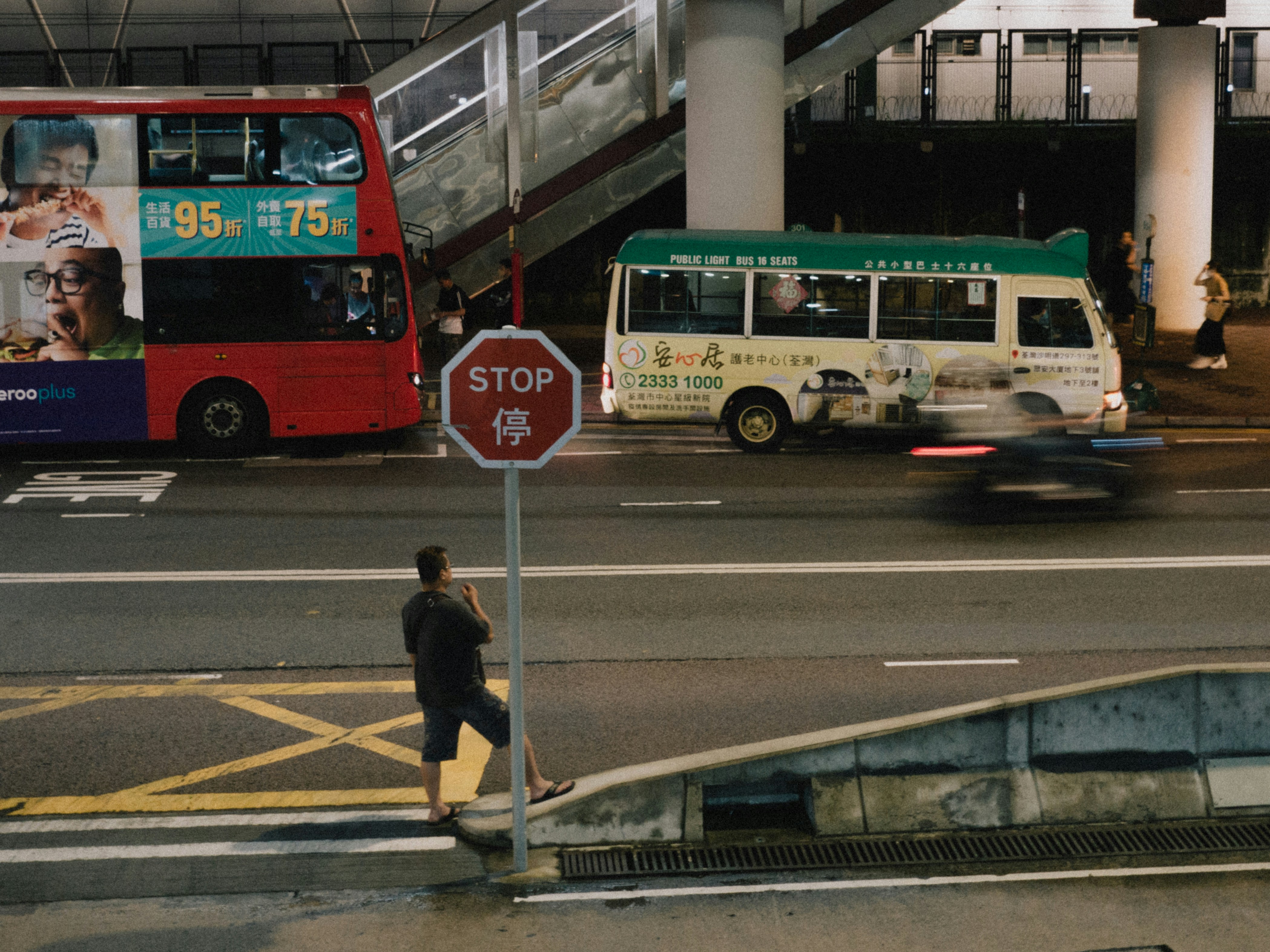 A red and white double decker bus driving past a red stop sign photo ...