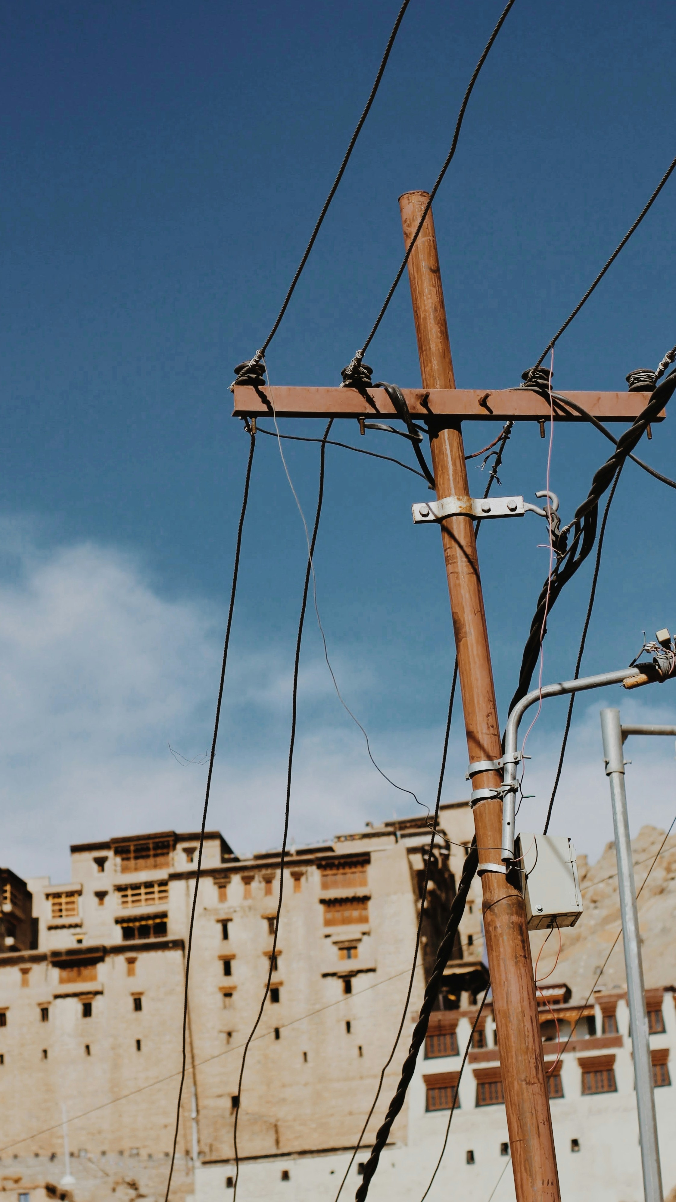 Wired Skyline: A Weathered Pole Framing a Desert Town