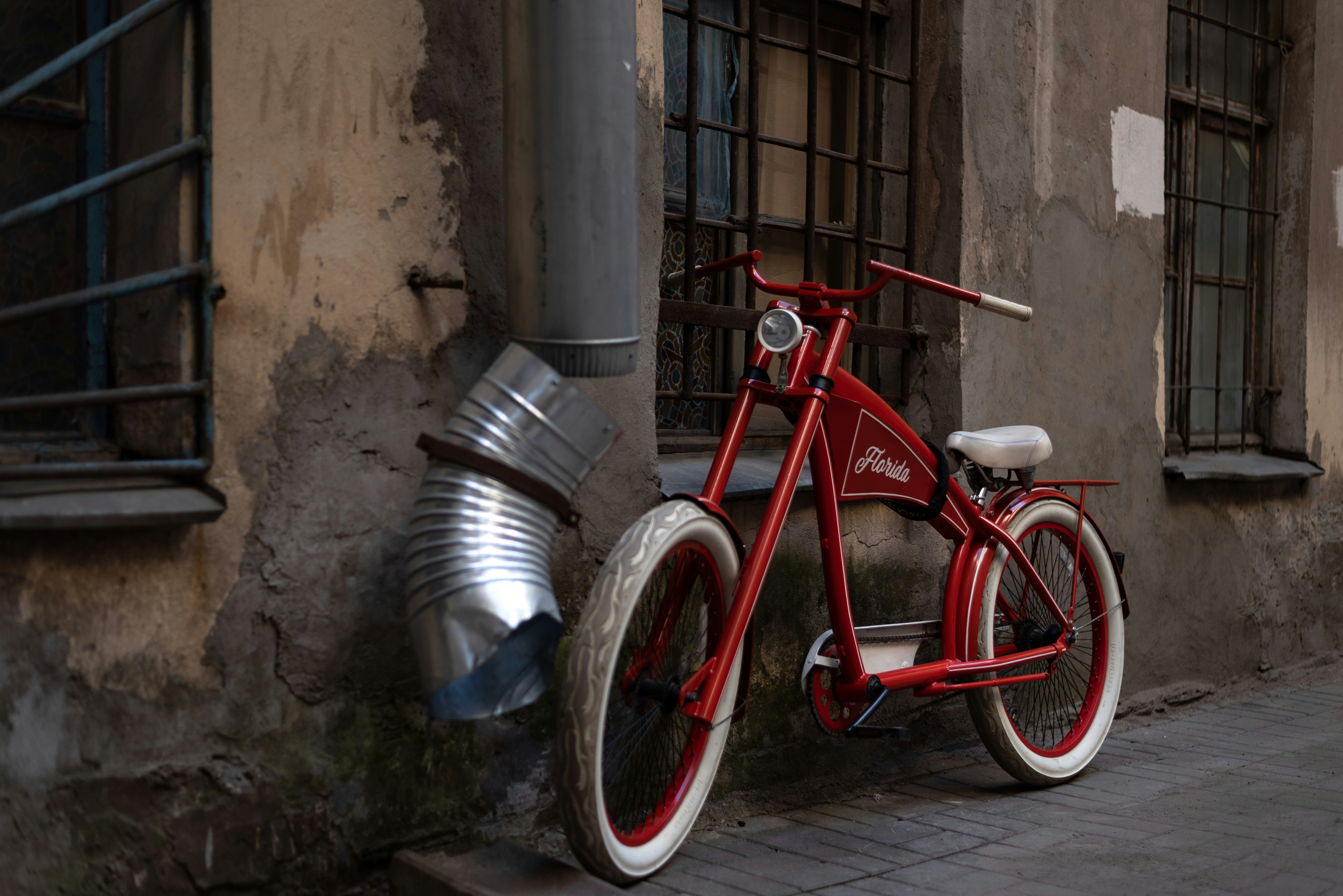 Crimson Vintage Bicycle Leaning Against a Weathered Alley Wall