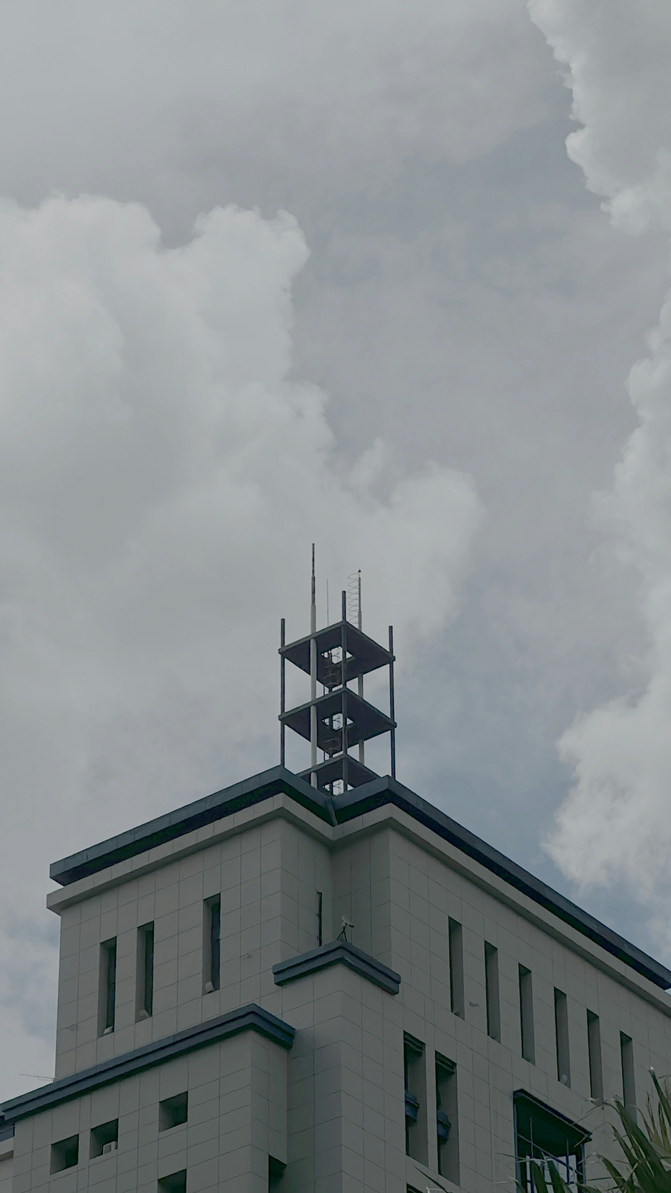 Apex of the Tower: Antenna Crown Over a Modern Facade