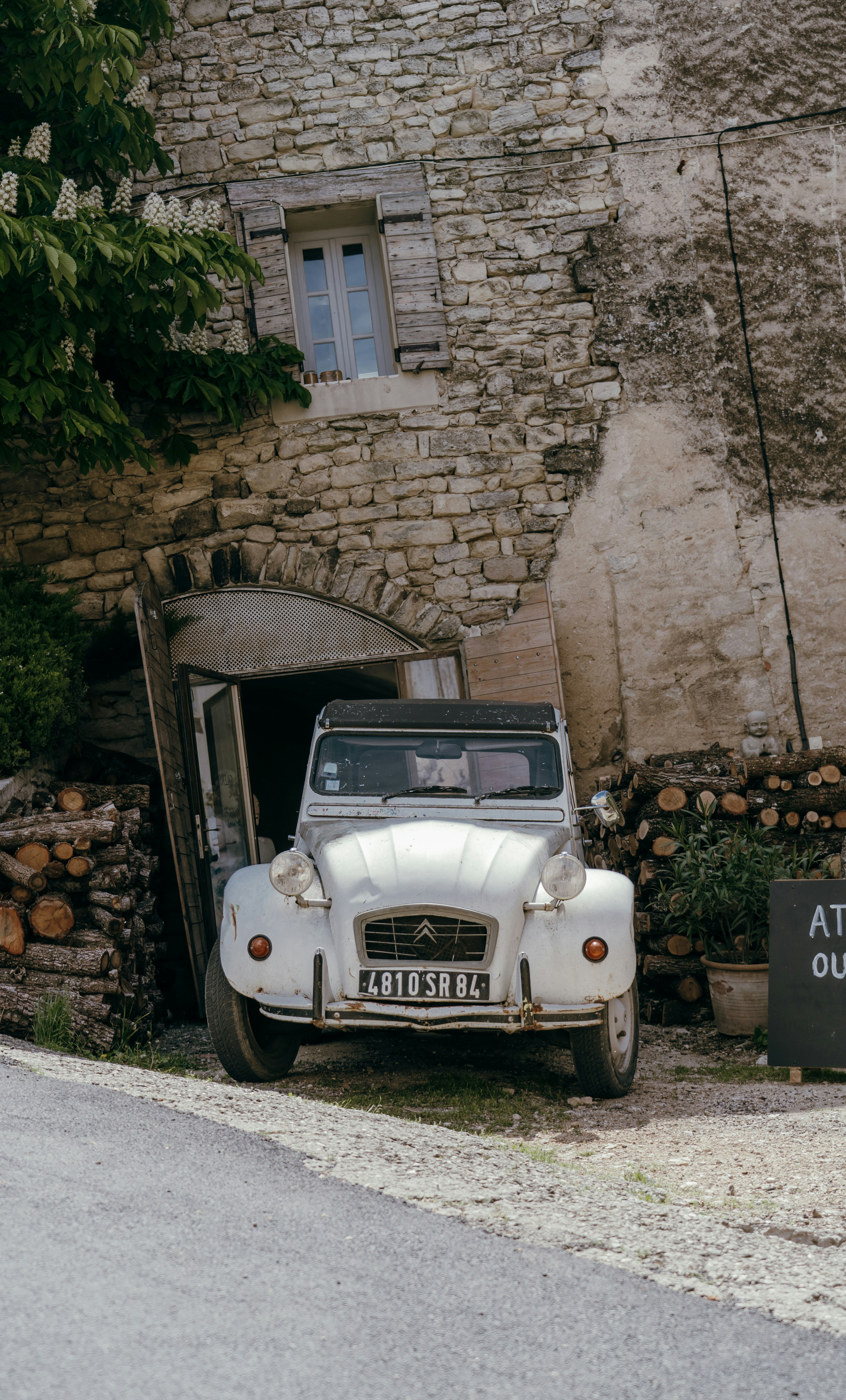 Stone Arch, White Citroën: A Quiet Moment by the Rustic Cottage