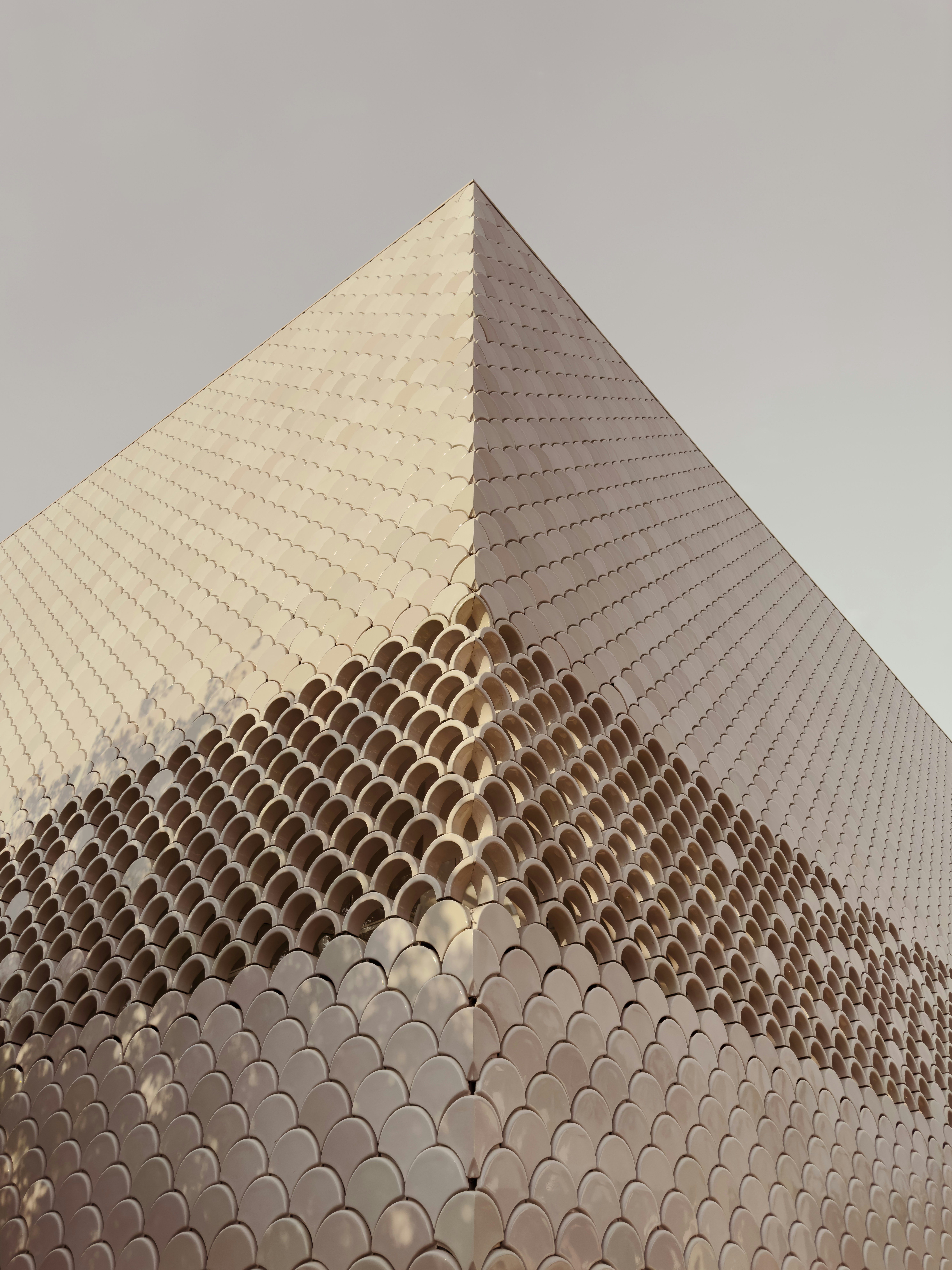 A very tall building with a very large triangular design on it's side ...