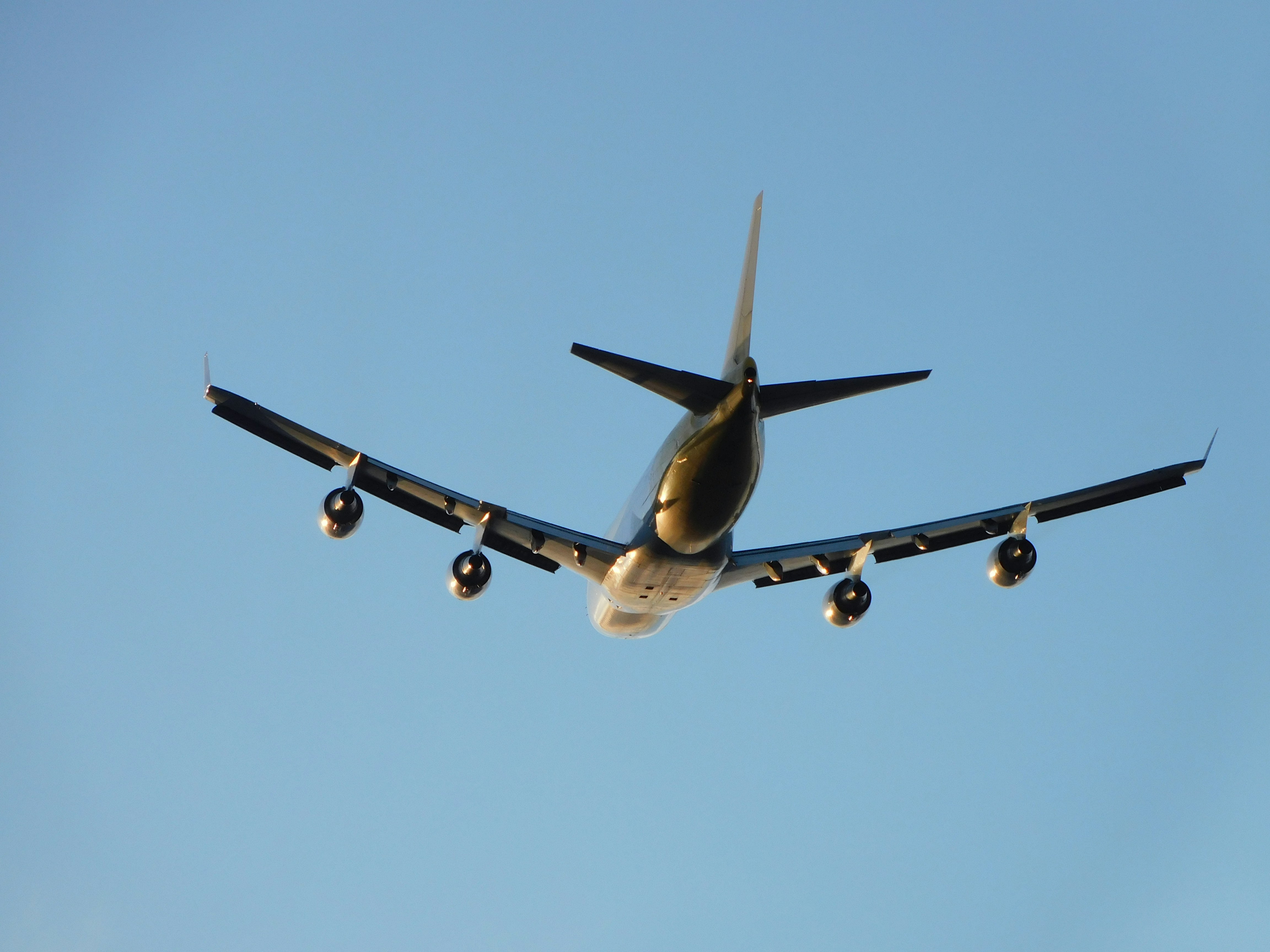 Boeing 747 soaring upward against a clear blue sky.