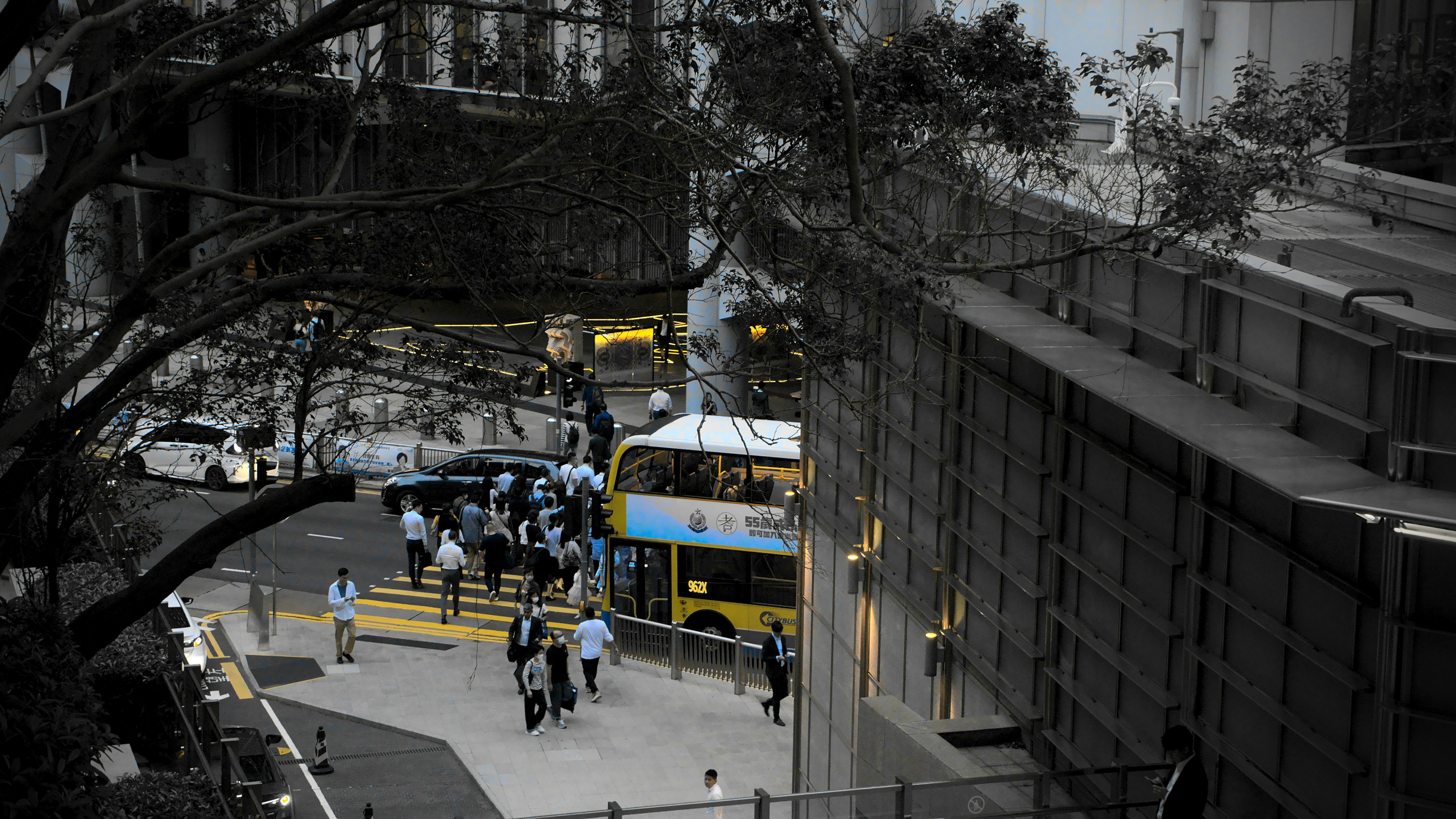 A group of people walking down a sidewalk next to a bus photo – Free ...