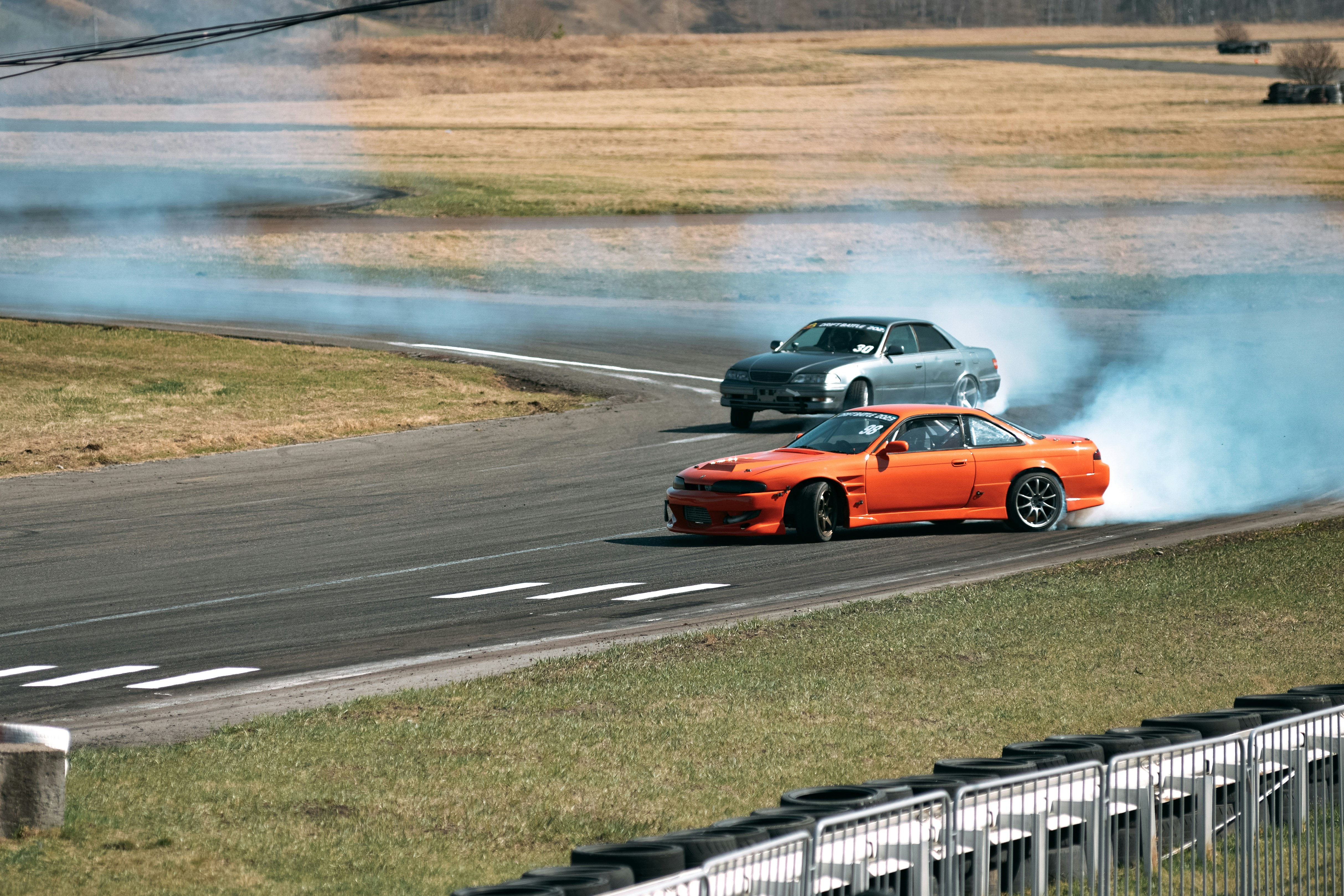 Orange Drift at the Curve: Tire Smoke Marks the Raceway