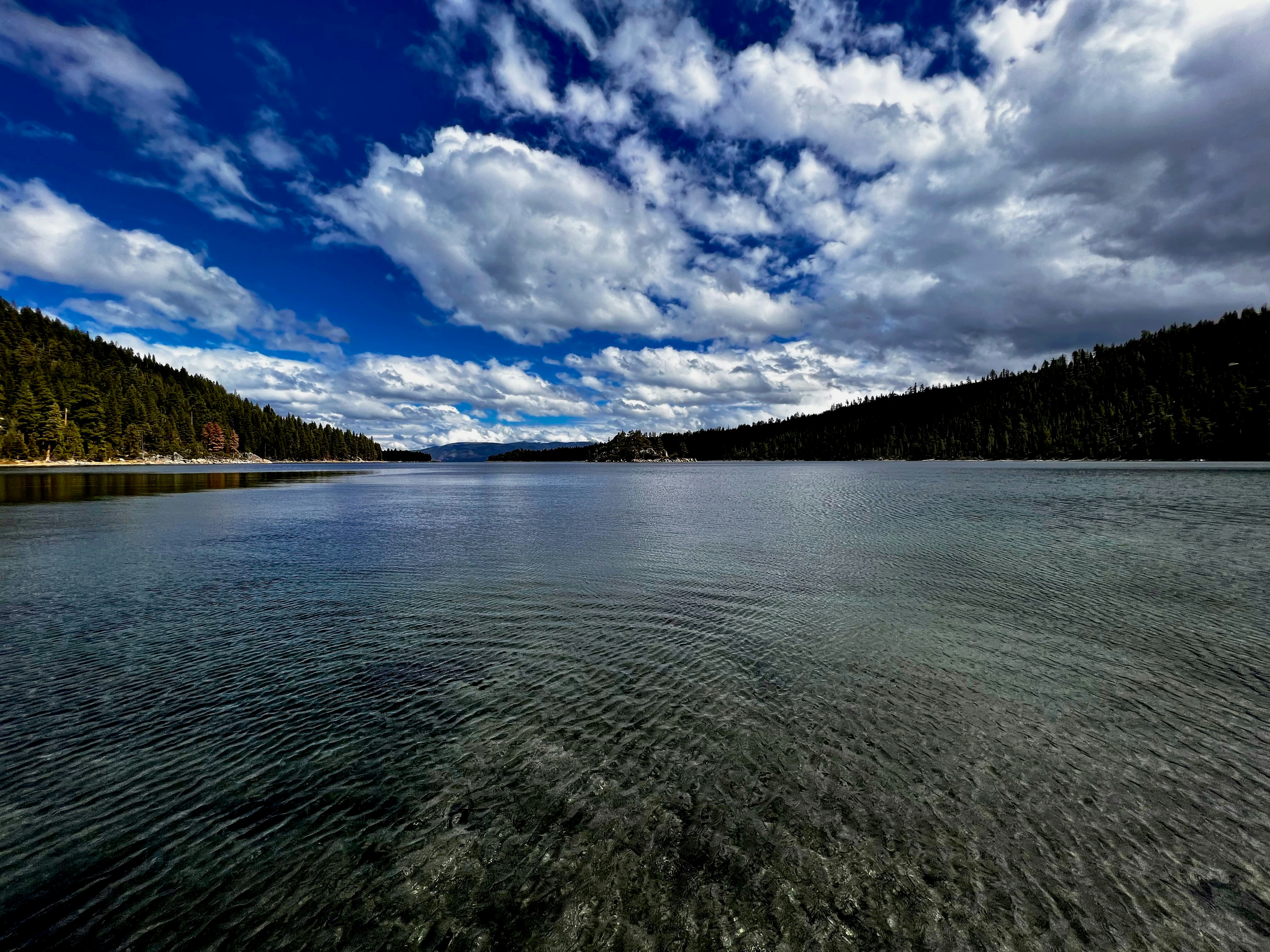 A large body of water surrounded by forest photo – Free Emerald bay Image on Unsplash