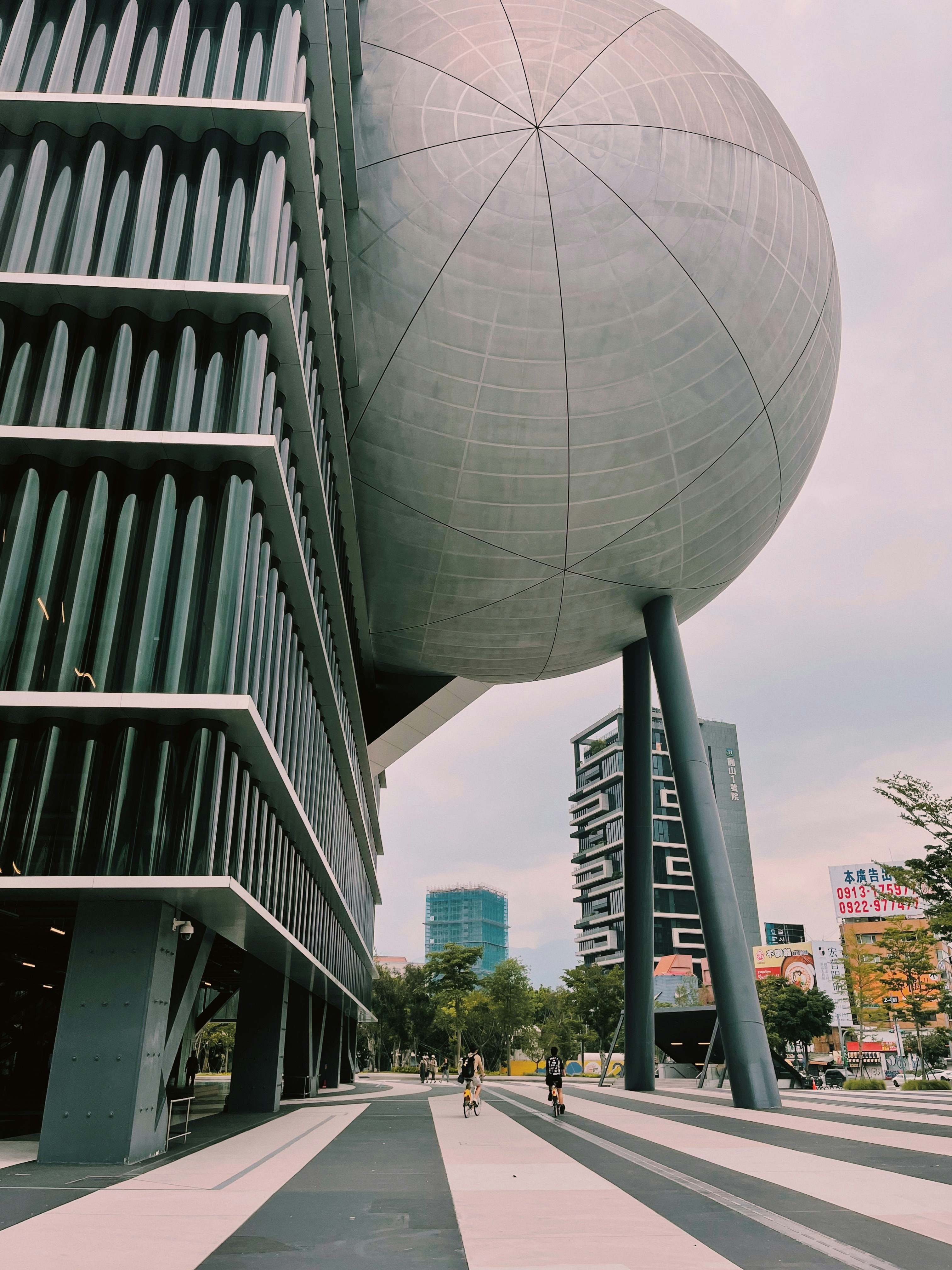 Orb Over Ribbed Facade: A Modern Urban Confluence
