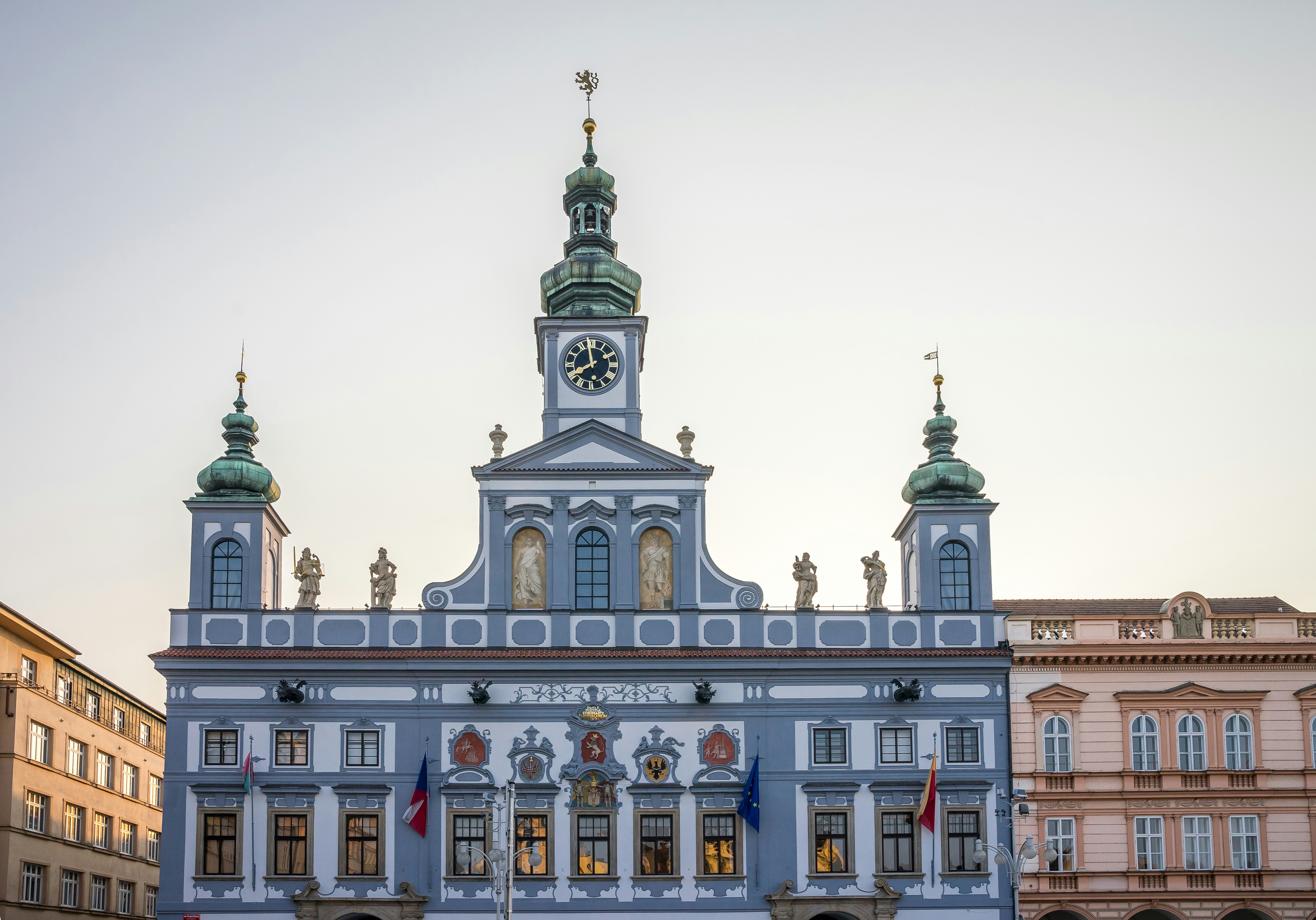 Ornate historic building with multiple spires and a clock tower against a clear evening sky.