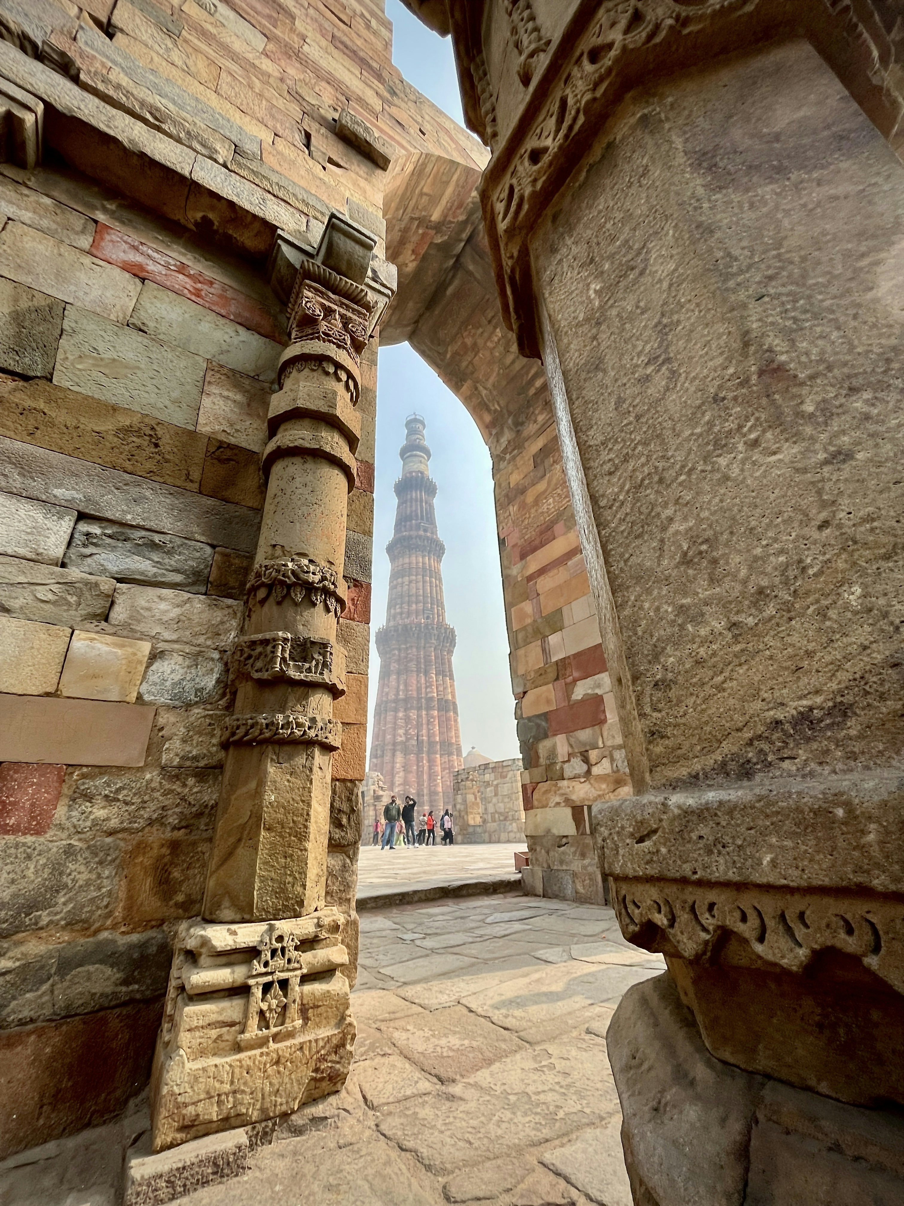 A tall tower towering over a city next to a stone wall photo – Free ...