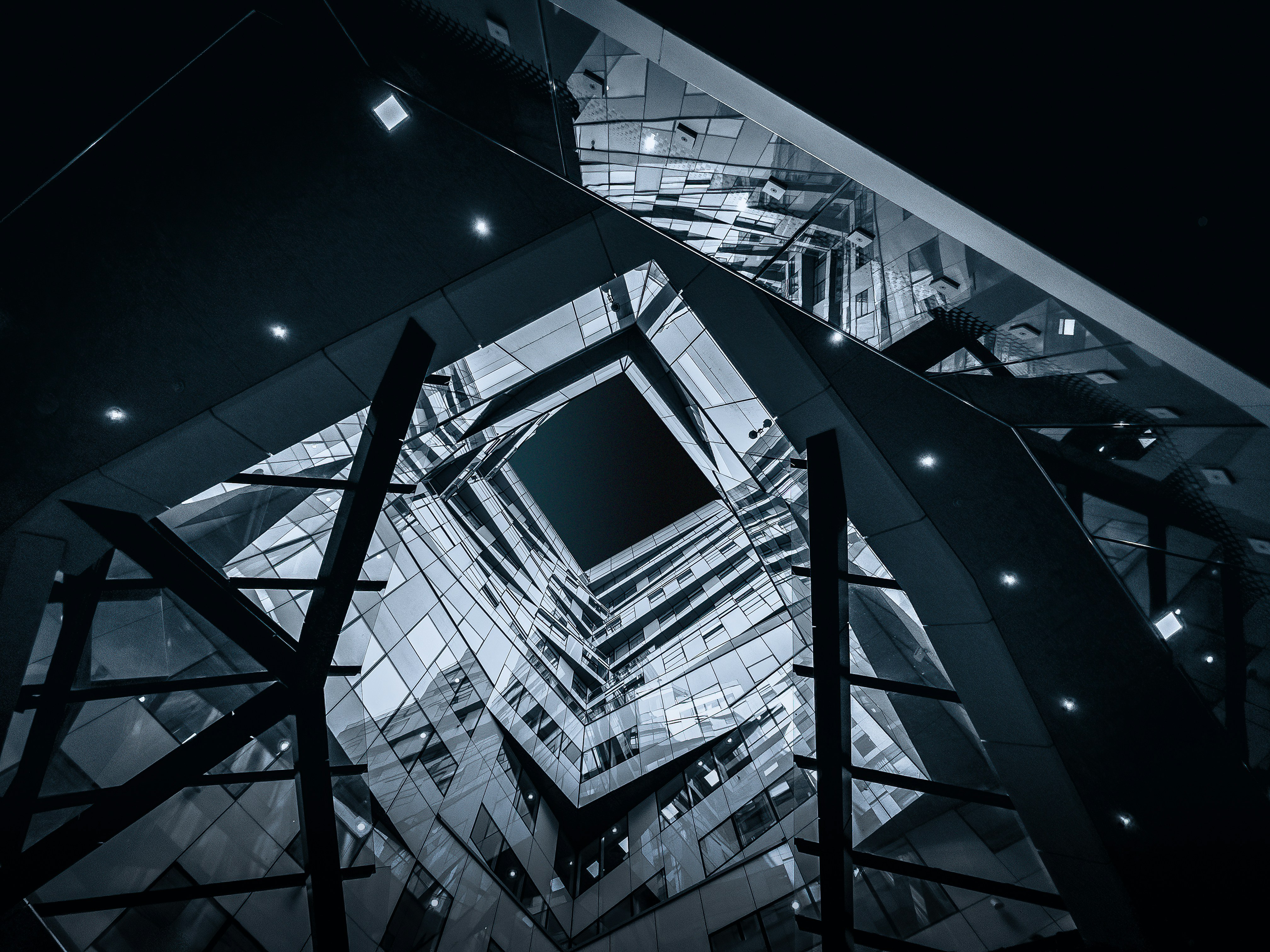 Abstract black and white view of a building's geometric structure illuminated at night.