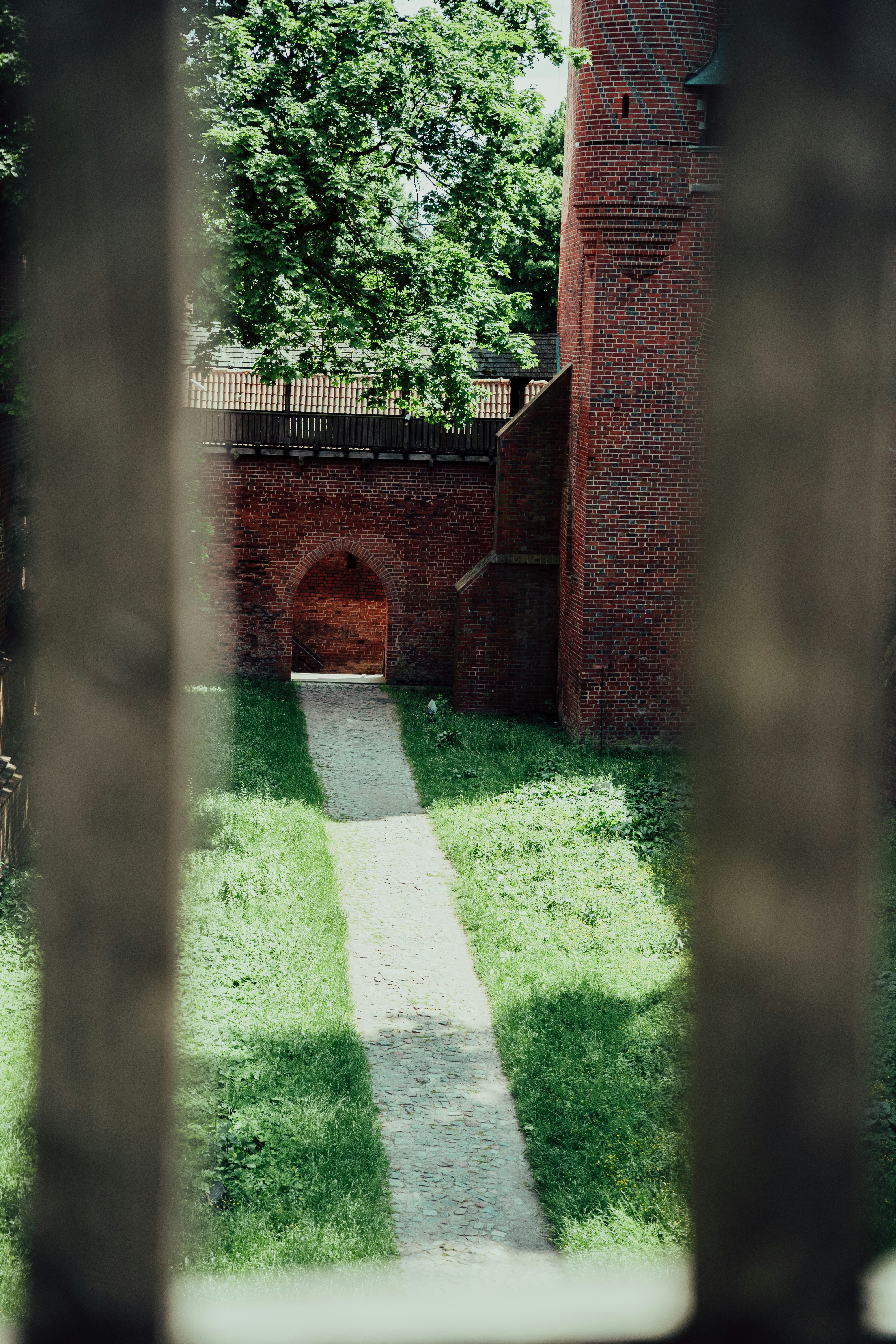 A view of a brick building through a window photo – Free Starościńska ...