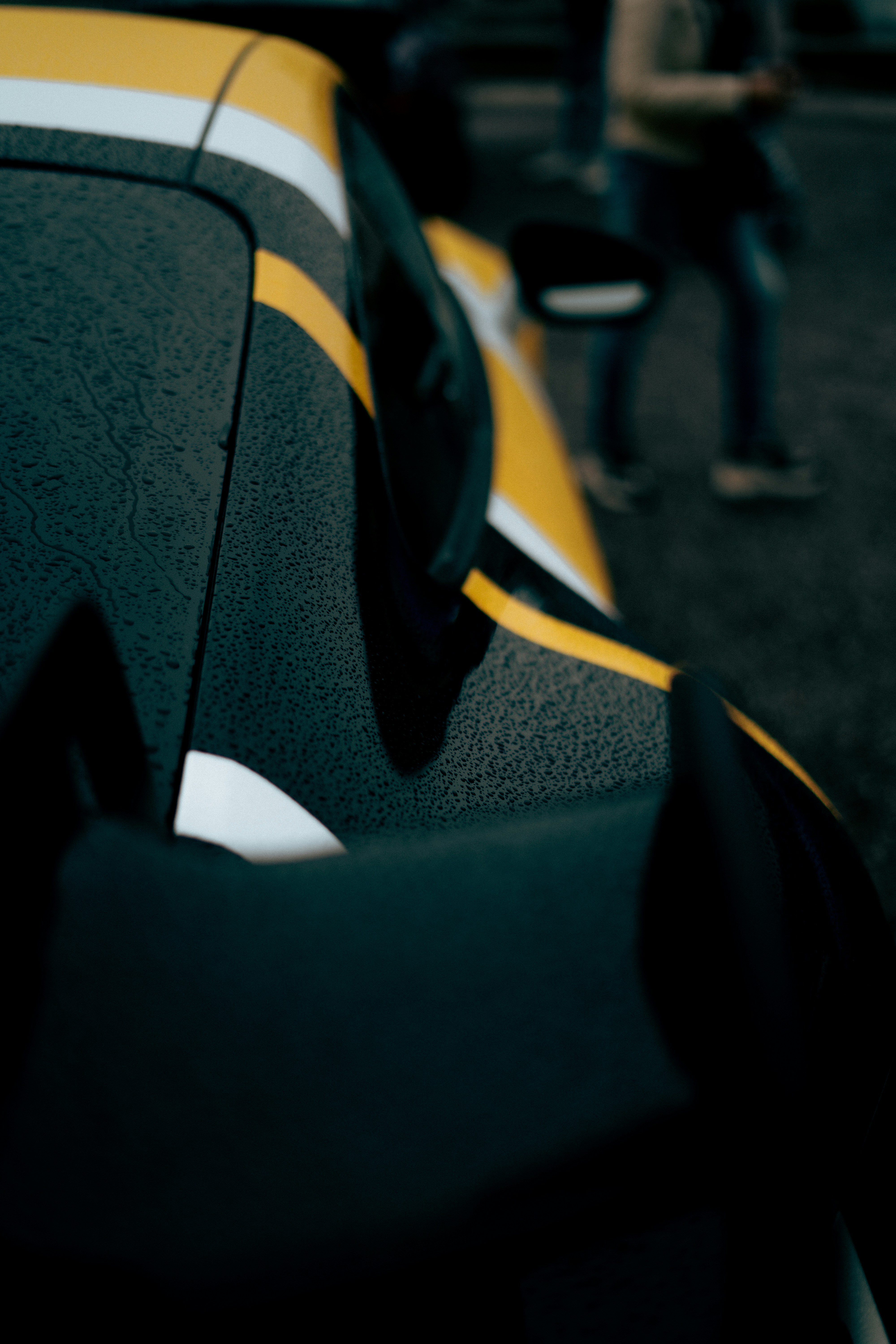Dew-Kissed Curves: A Close-Up of Wet Yellow Racing Stripes