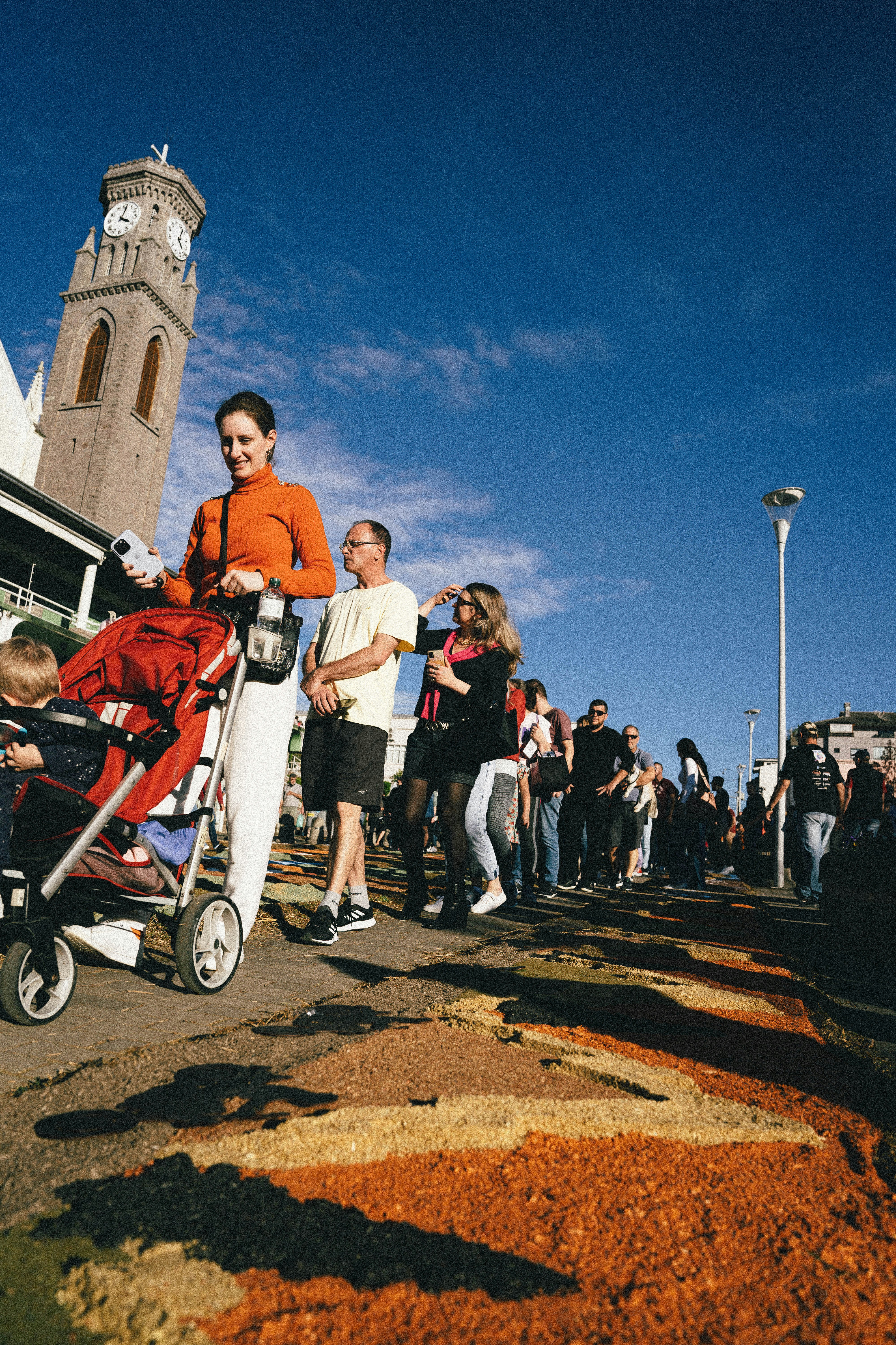A woman pushing a stroller in front of a crowd of people photo – Free ...