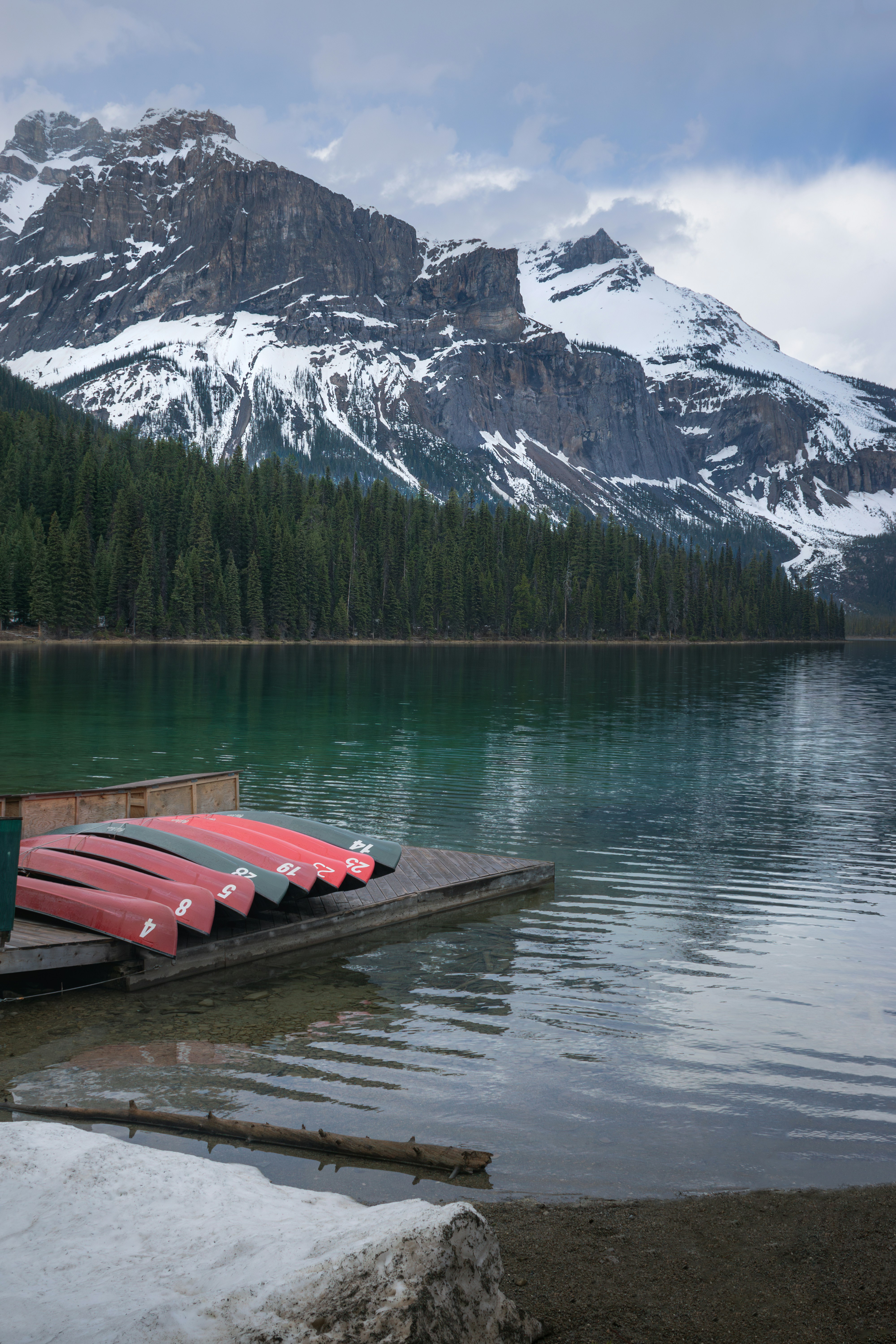 Emerald Lake Fjord: Canoes at the Edge of Snow-Scarred Peaks