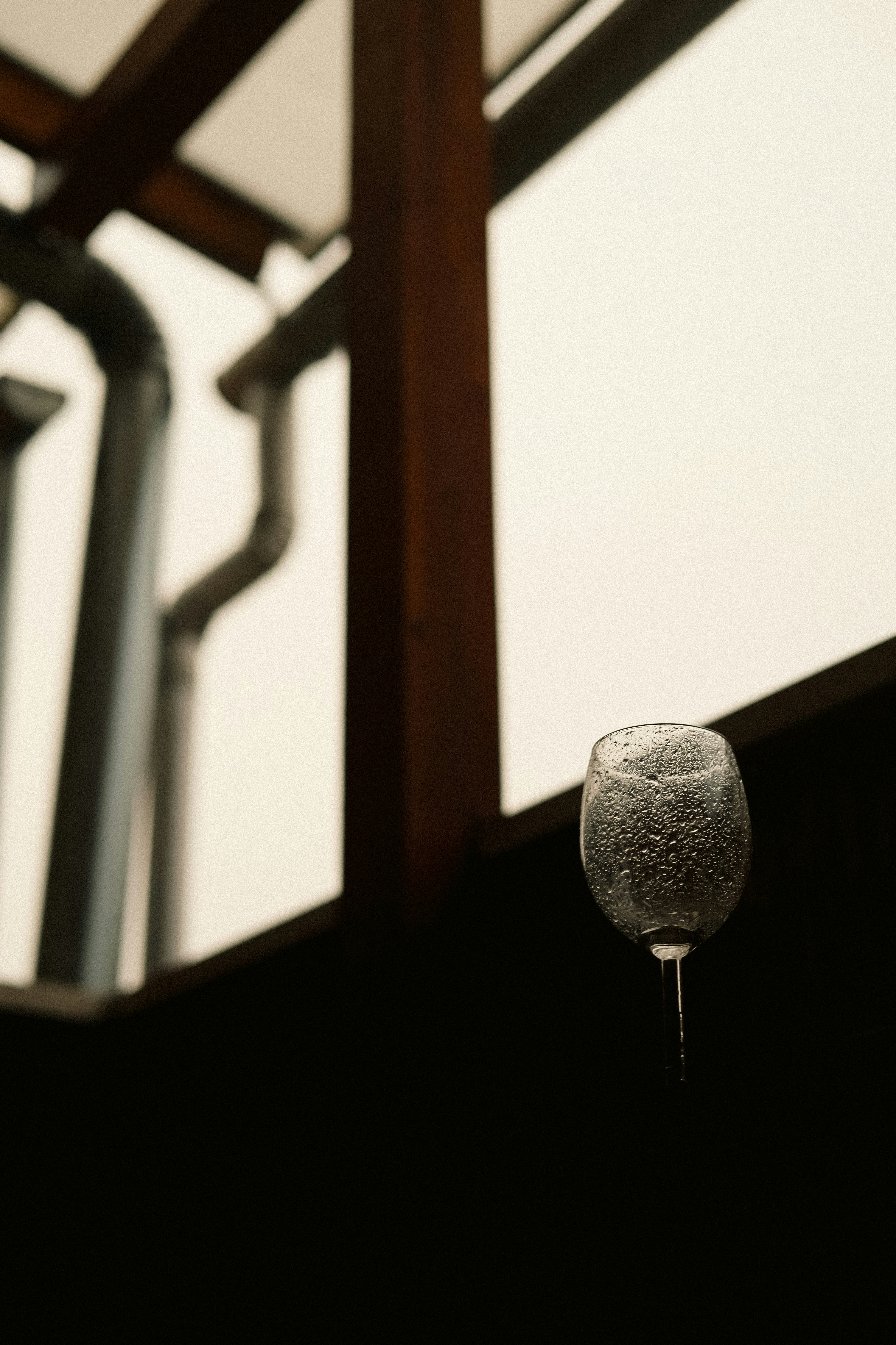 Dew on a Glass Goblet Amid Industrial Lines