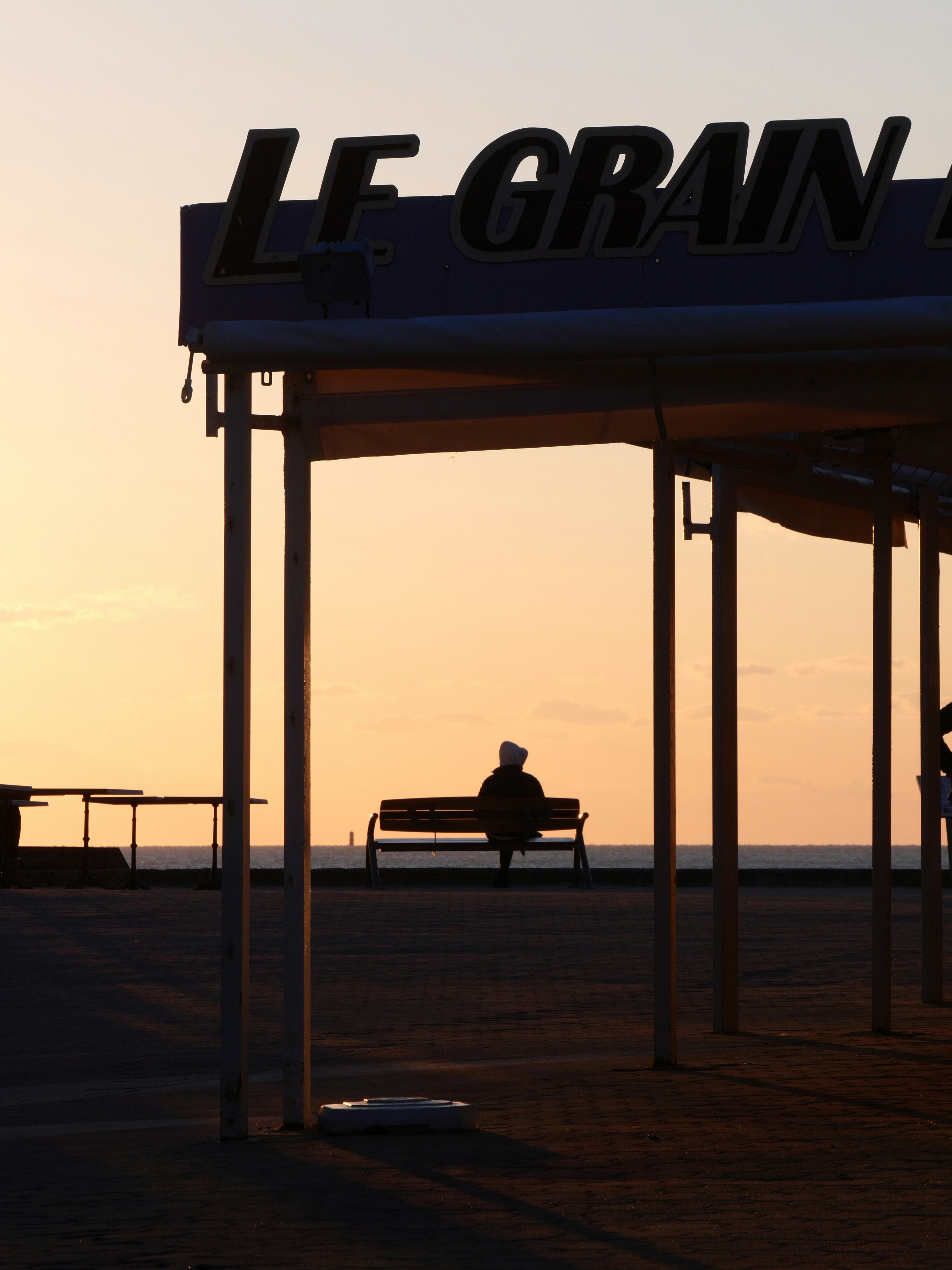 Silhouette on the Pier: A Quiet Sunset Moment