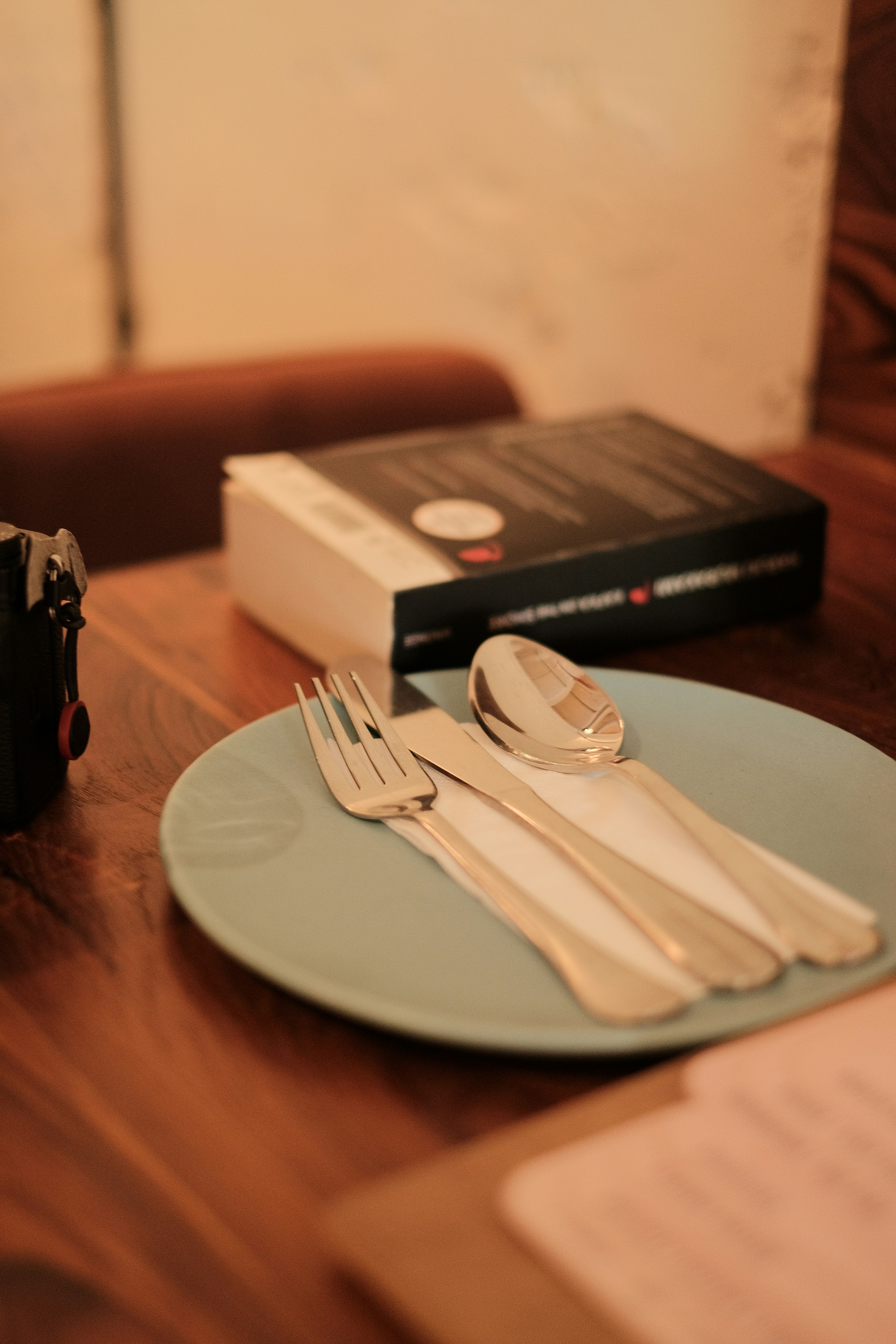 Teal Plate Still Life: Stainless Steel Silence Under Warm Ambient Light
