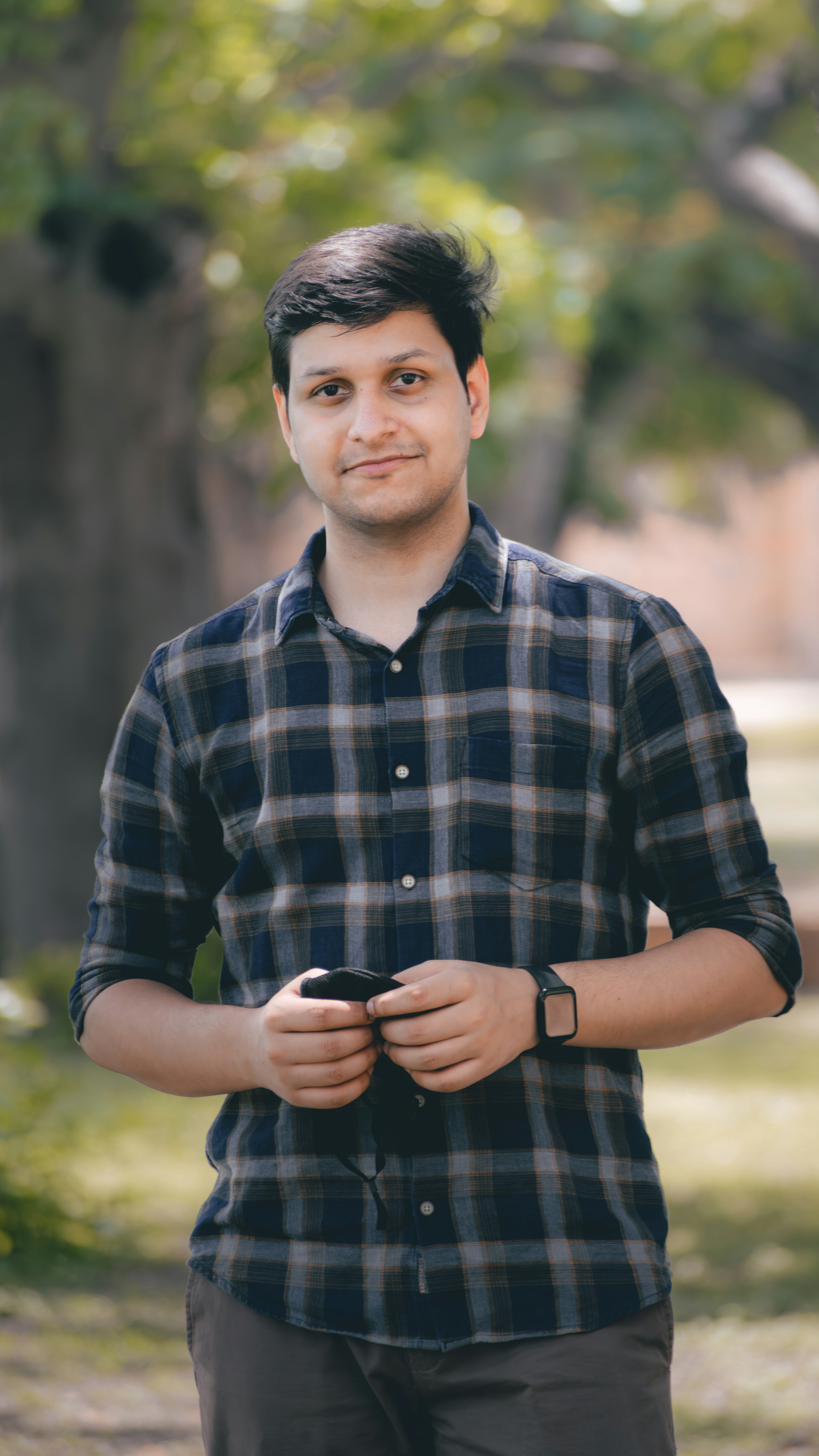 A man standing in a park looking at his cell phone photo – Free ...