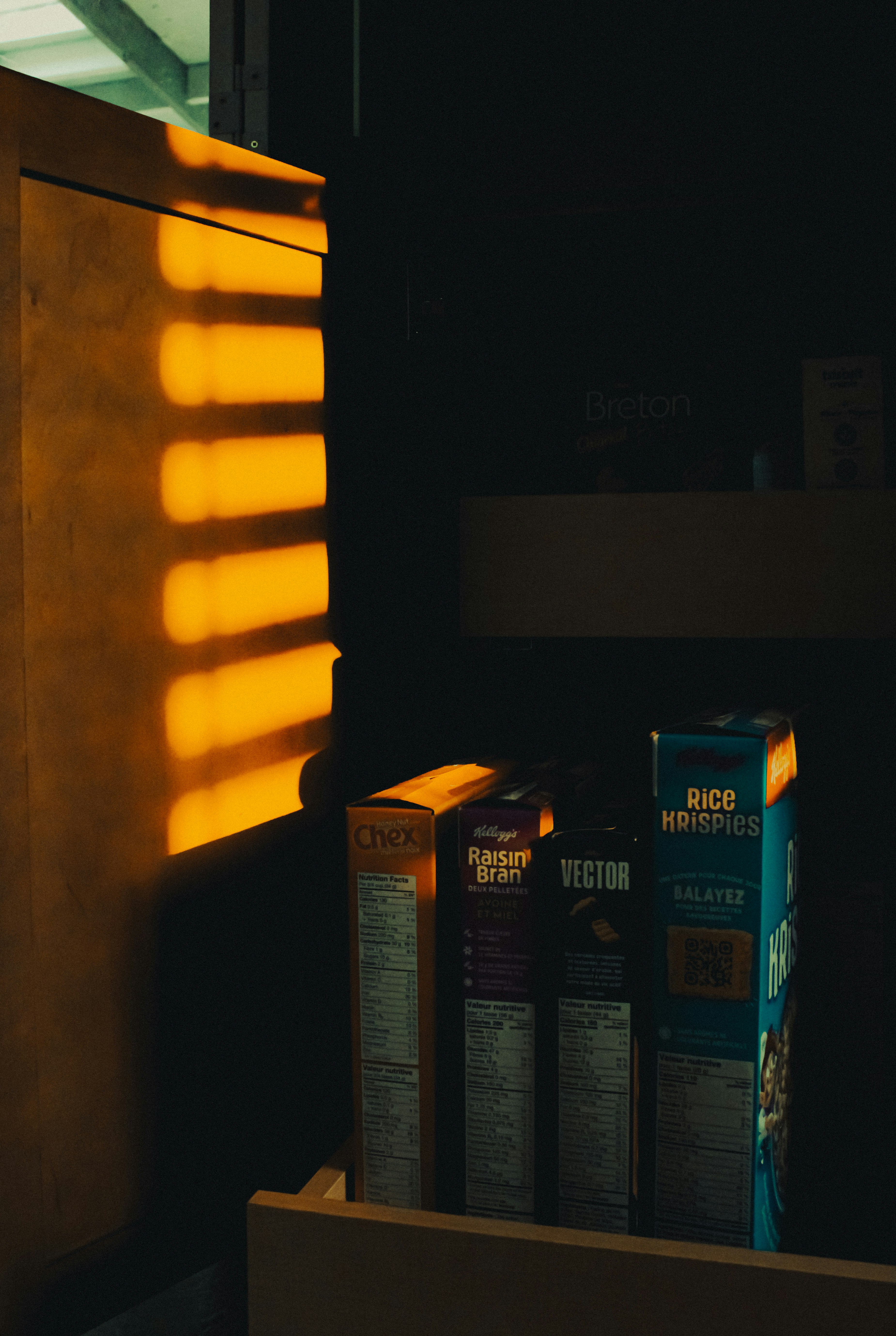 Amber Stripes on a Quiet Shelf: A Dimly Lit Cereal Still Life