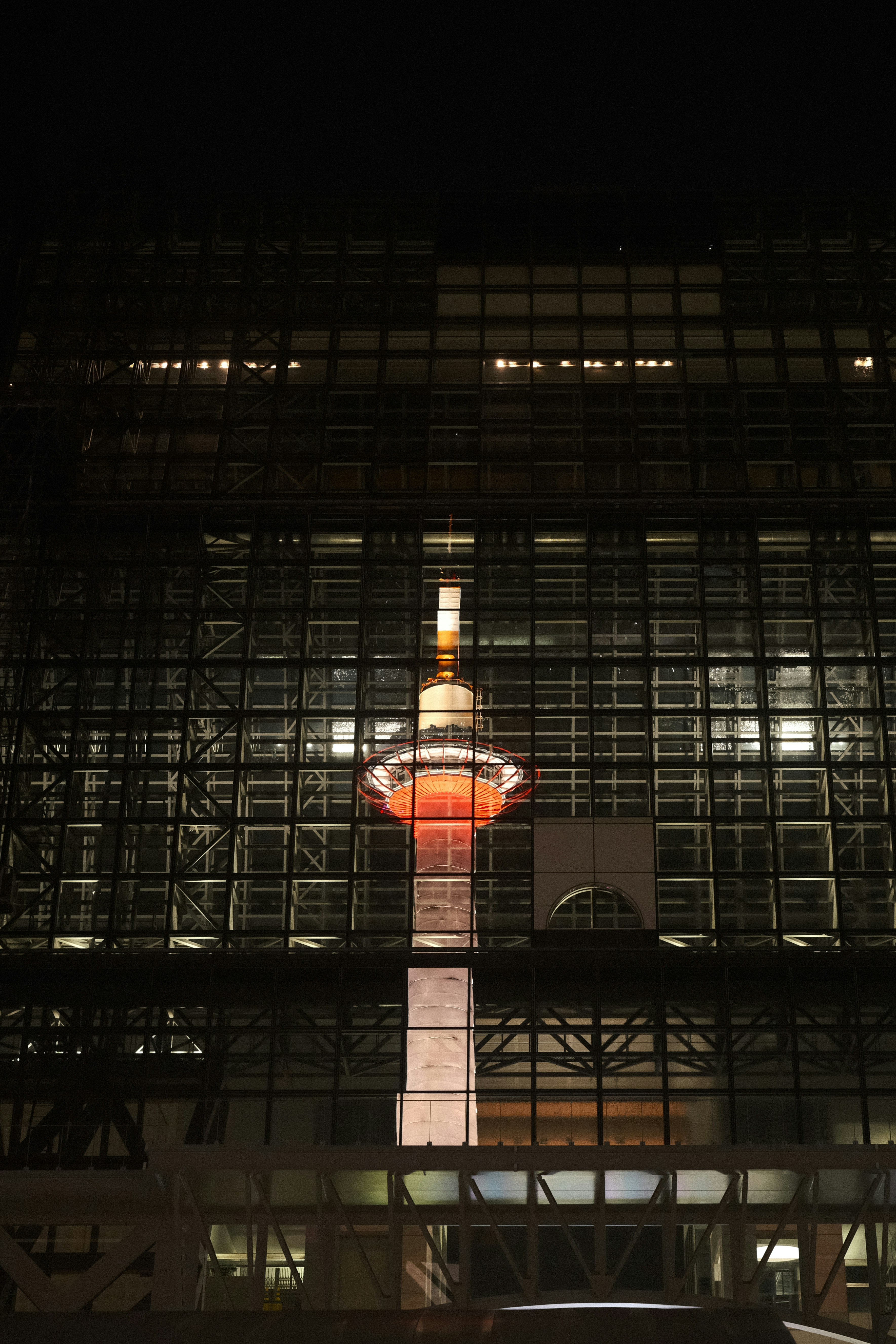 Crimson Spire Framed by a Lattice Glass Facade