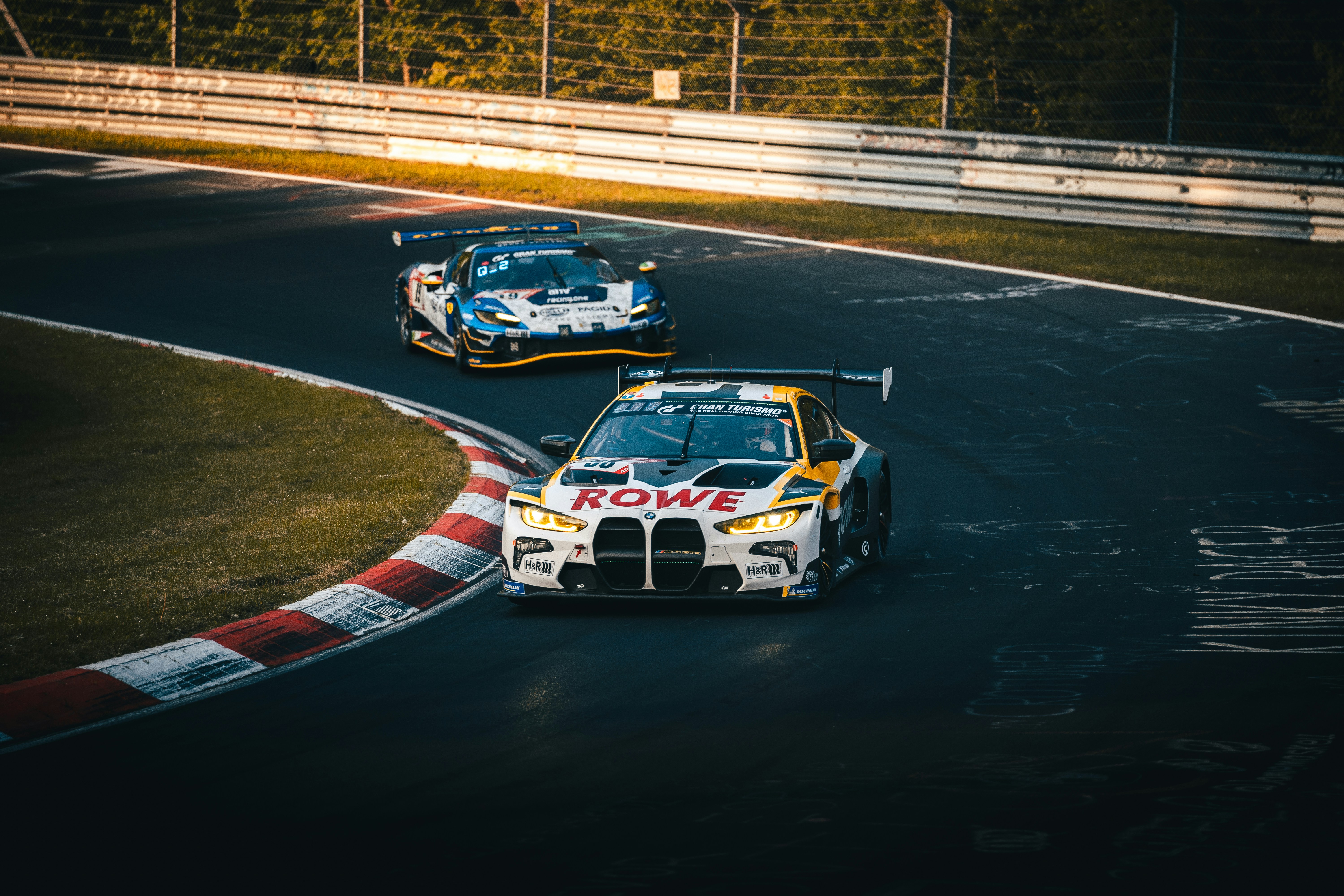 A couple of cars driving down a race track photo – Free Bmw Image on ...